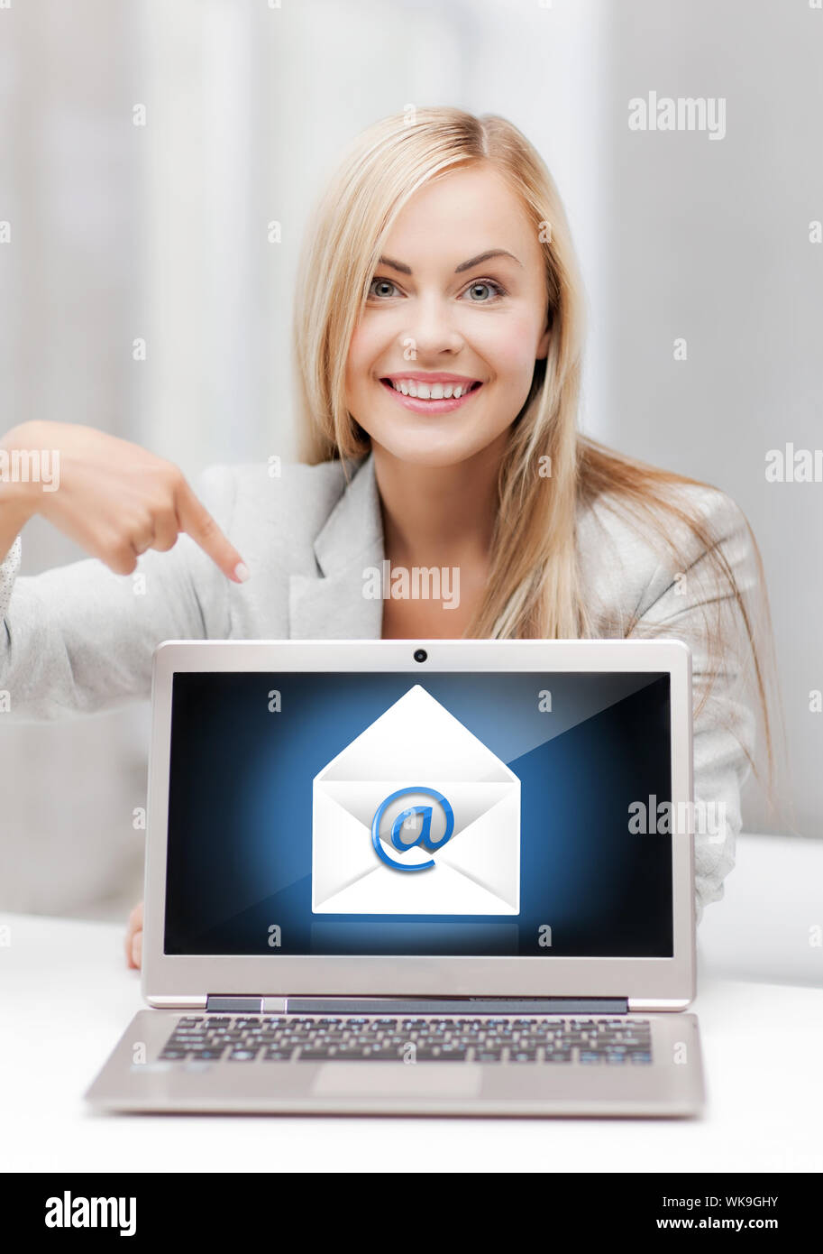 beautiful woman with laptop pointing at email sign Stock Photo - Alamy