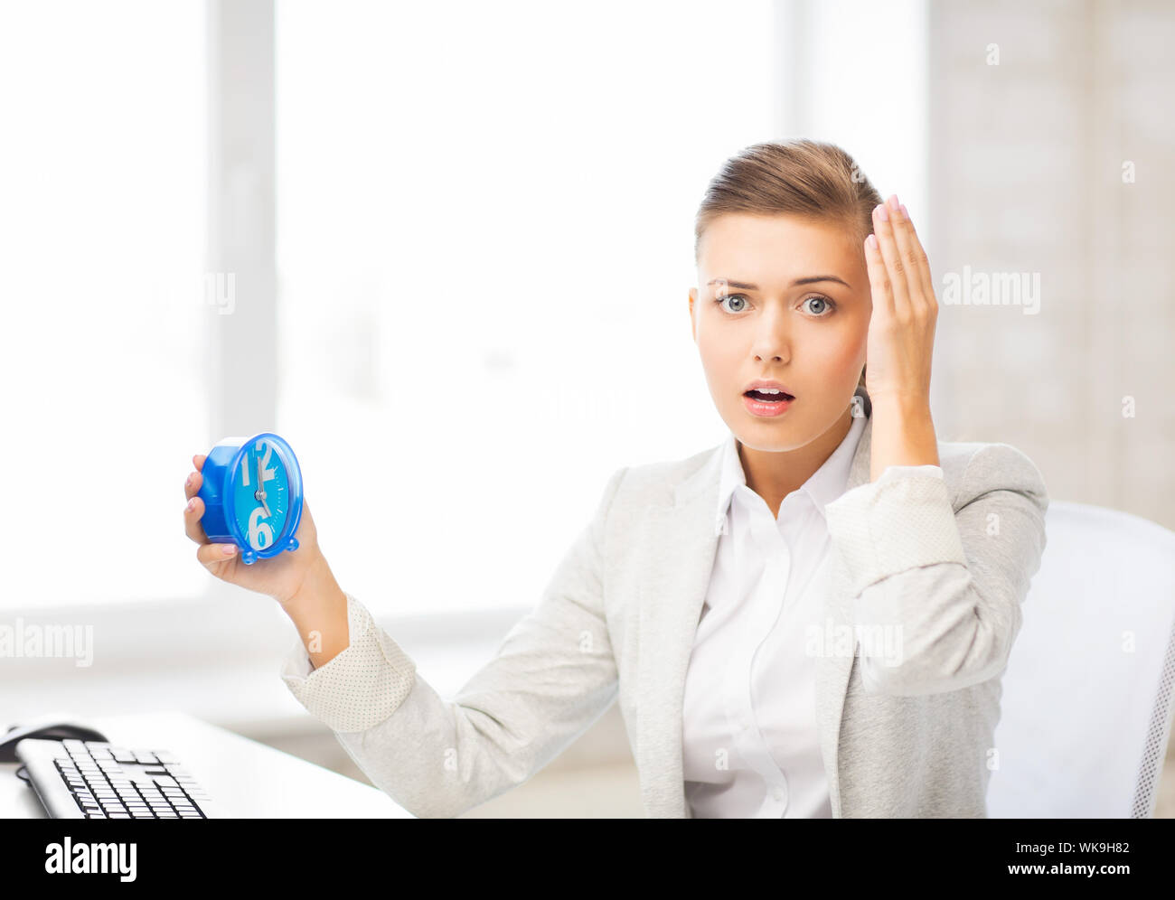 stressed businesswoman holding clock Stock Photo - Alamy
