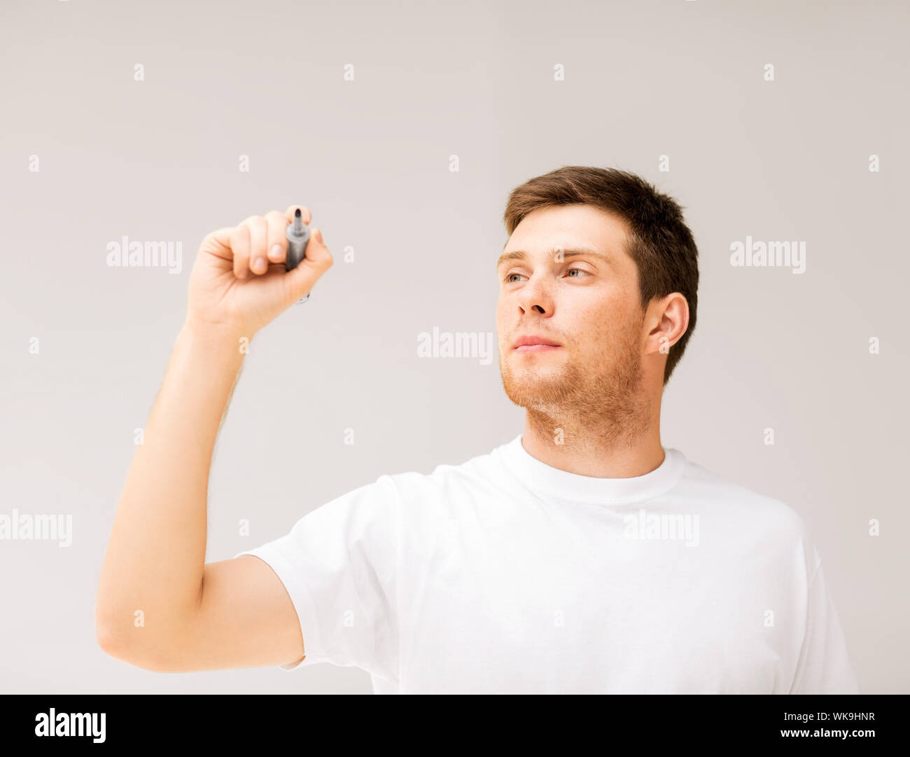 man writing something in the air with marker Stock Photo - Alamy