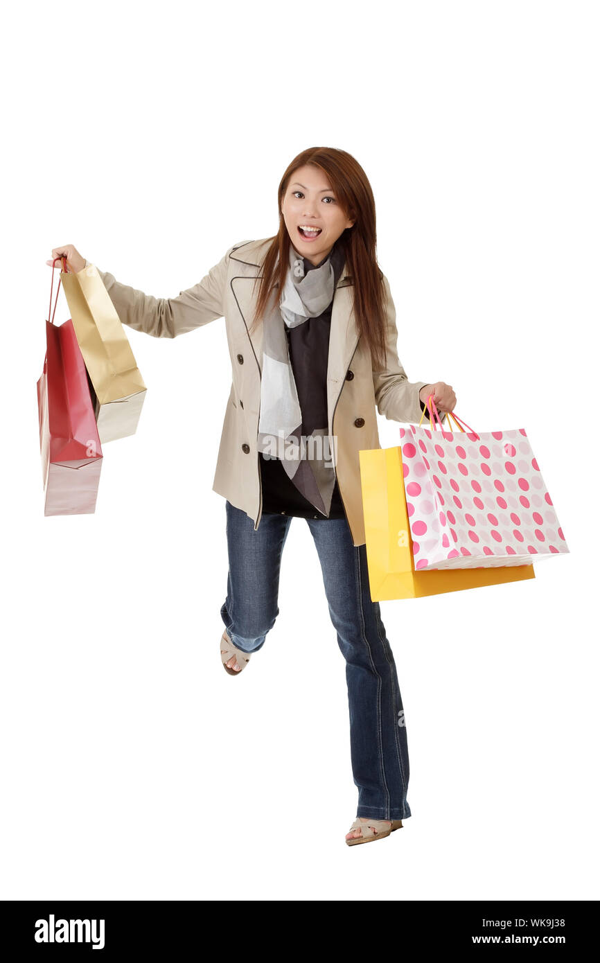 Exciting shopping woman of Asian holding bags isolated over white Stock ...