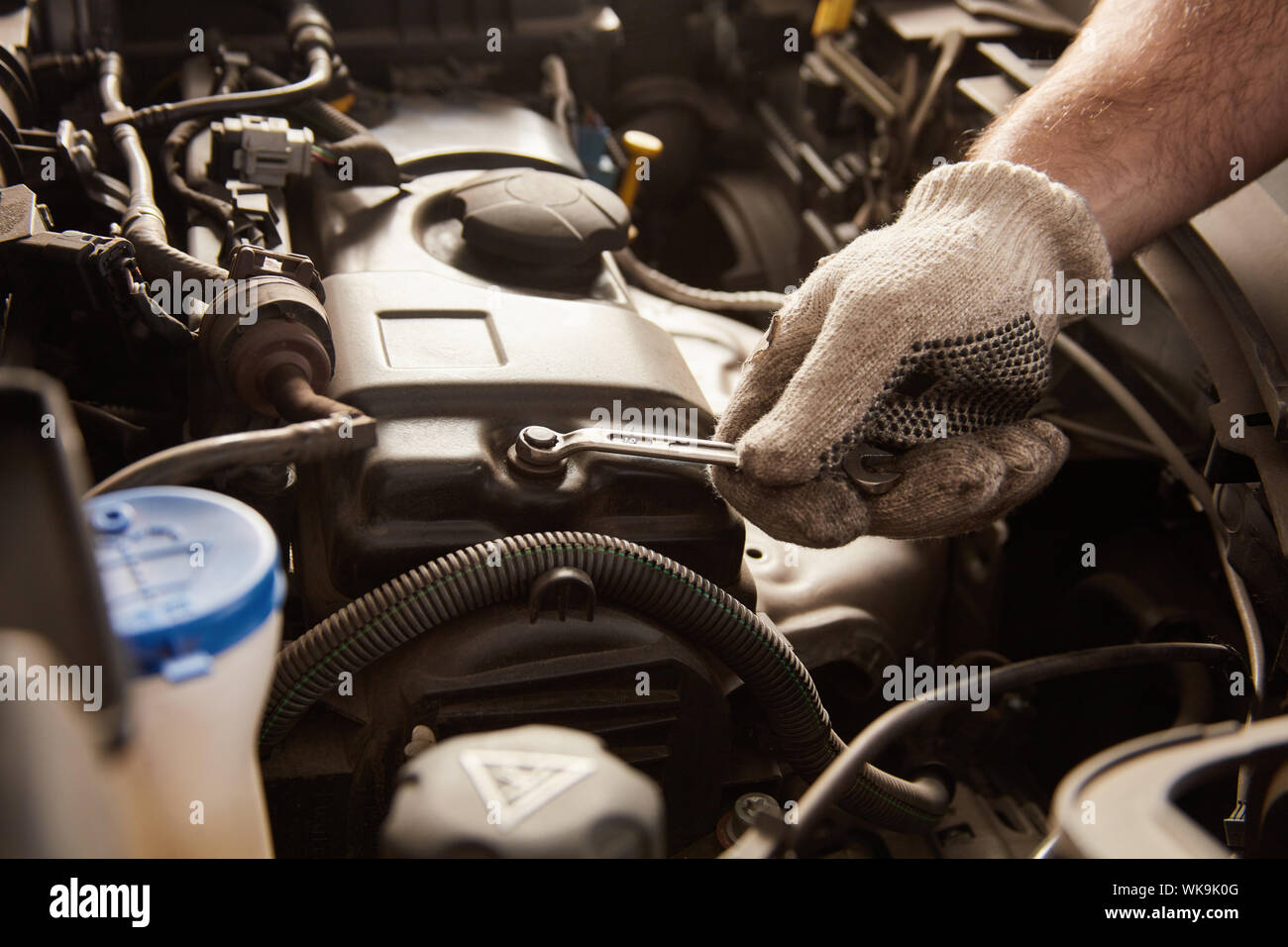 Hand with tool during inspection or repair of car engine in the ...