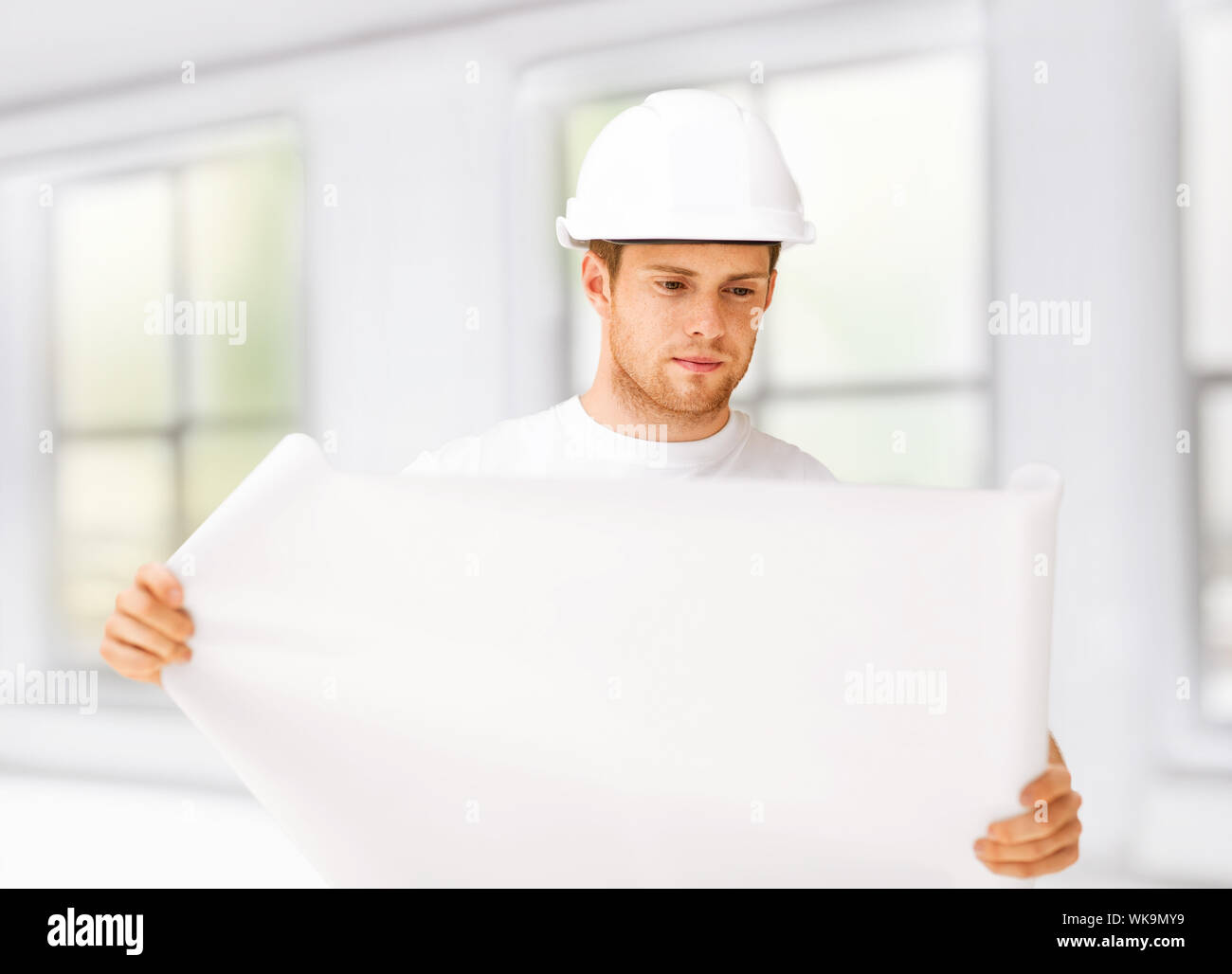 male architect looking at blueprint at home Stock Photo - Alamy