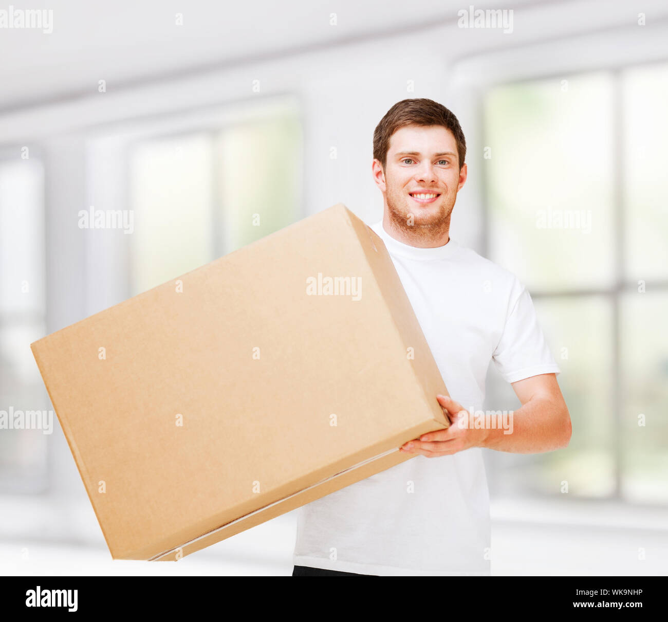 new home and post delivery concept - smiling man carrying carton box ...