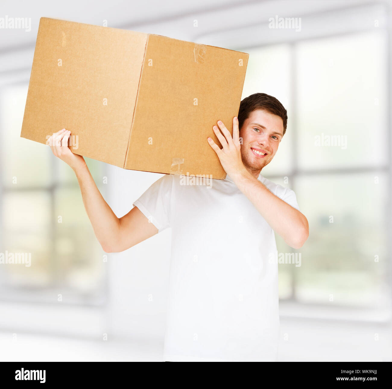 new home and post delivery concept - smiling man carrying carton box ...