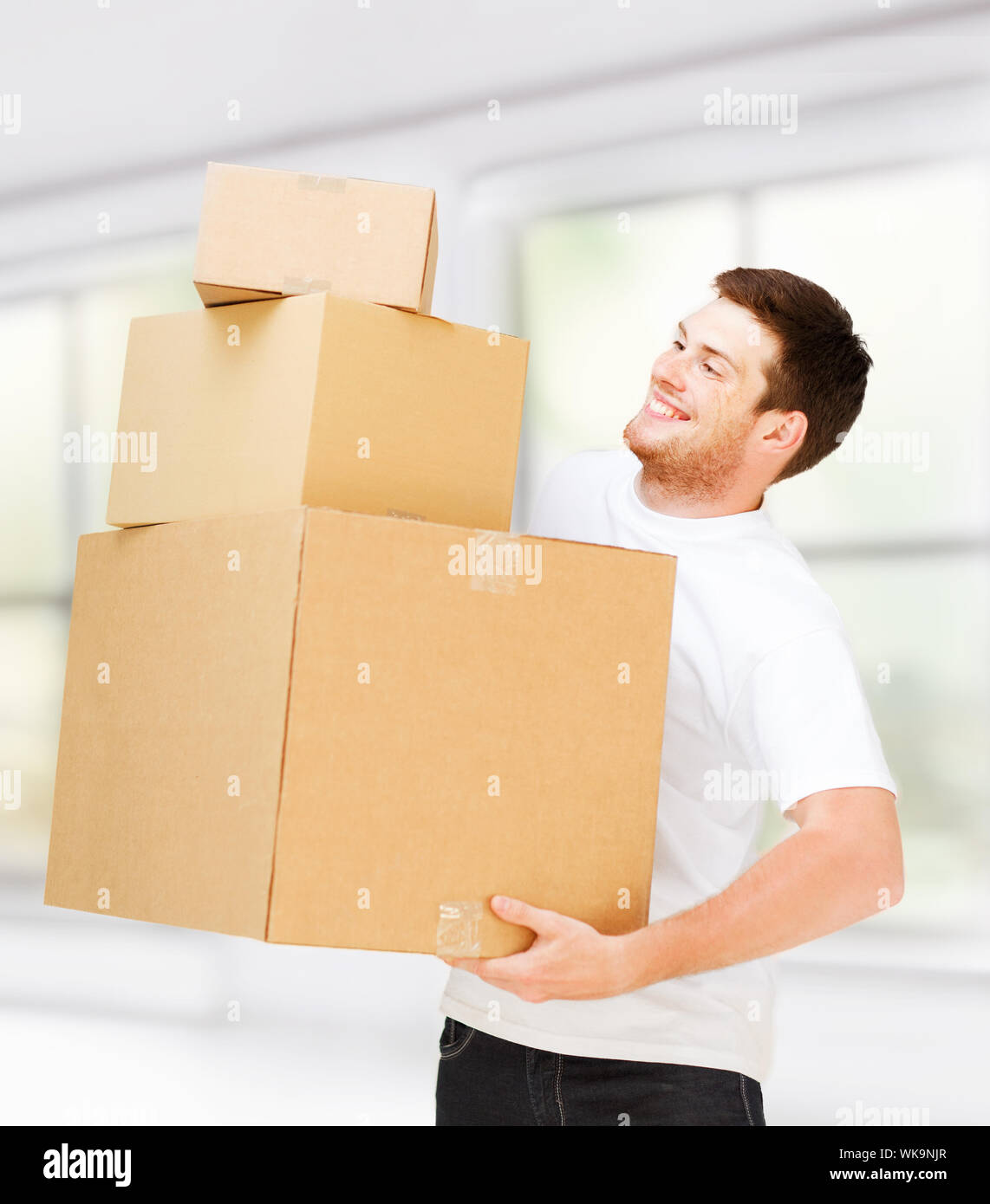 new home and post delivery concept - young man carrying carton boxes ...
