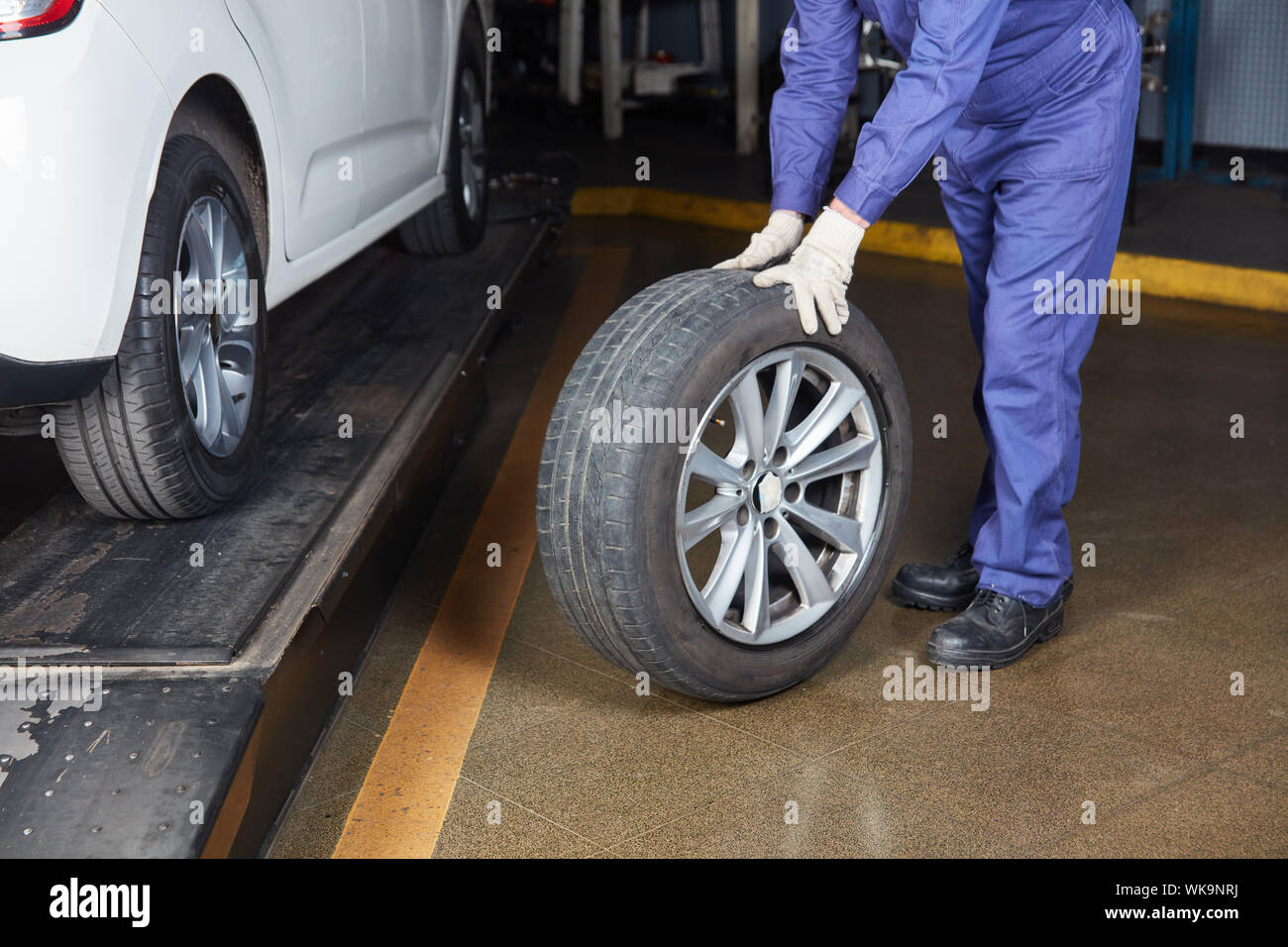 Mechanic at the tire change at the auto repair shop during a ...