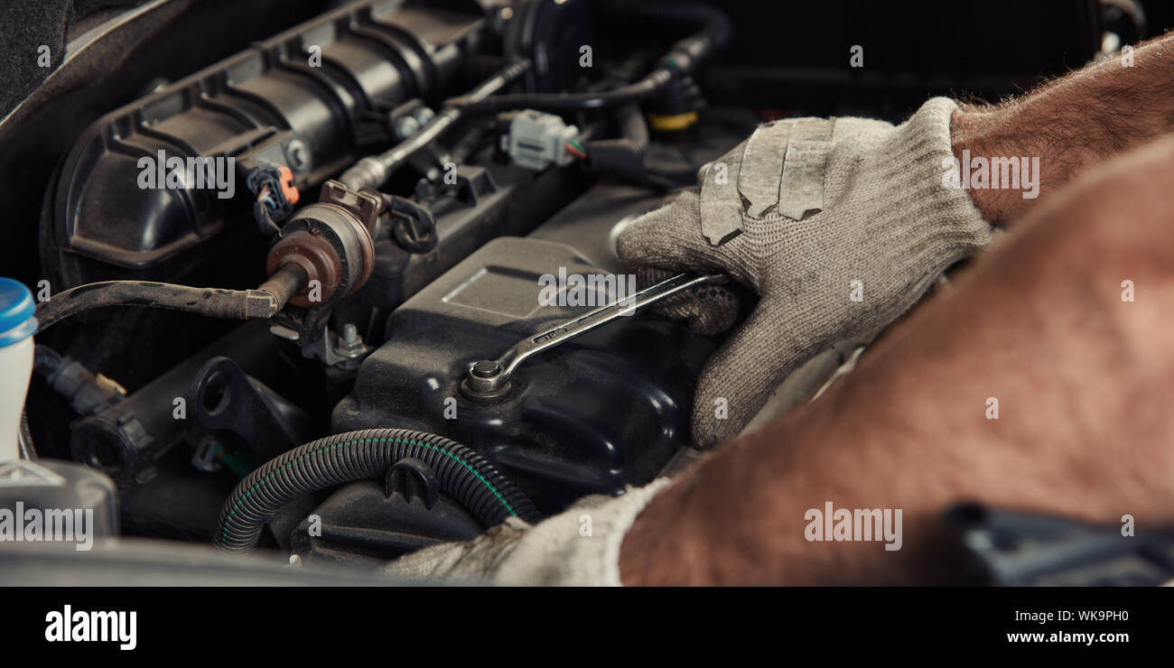 Hand of the mechatronics engineer at the engine in the car repairing in ...