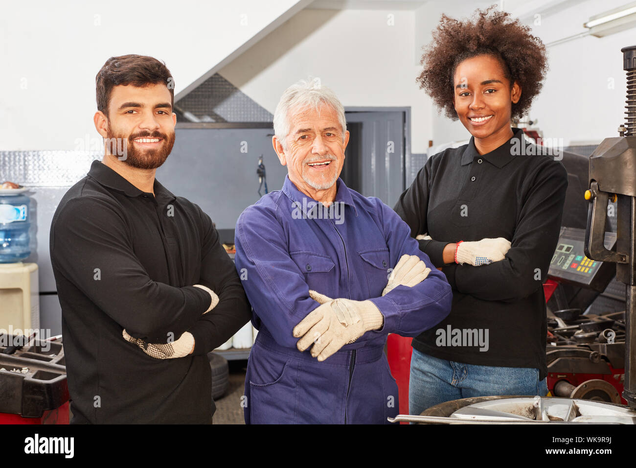 Multicultural mechanic team with apprentice and master in the auto ...