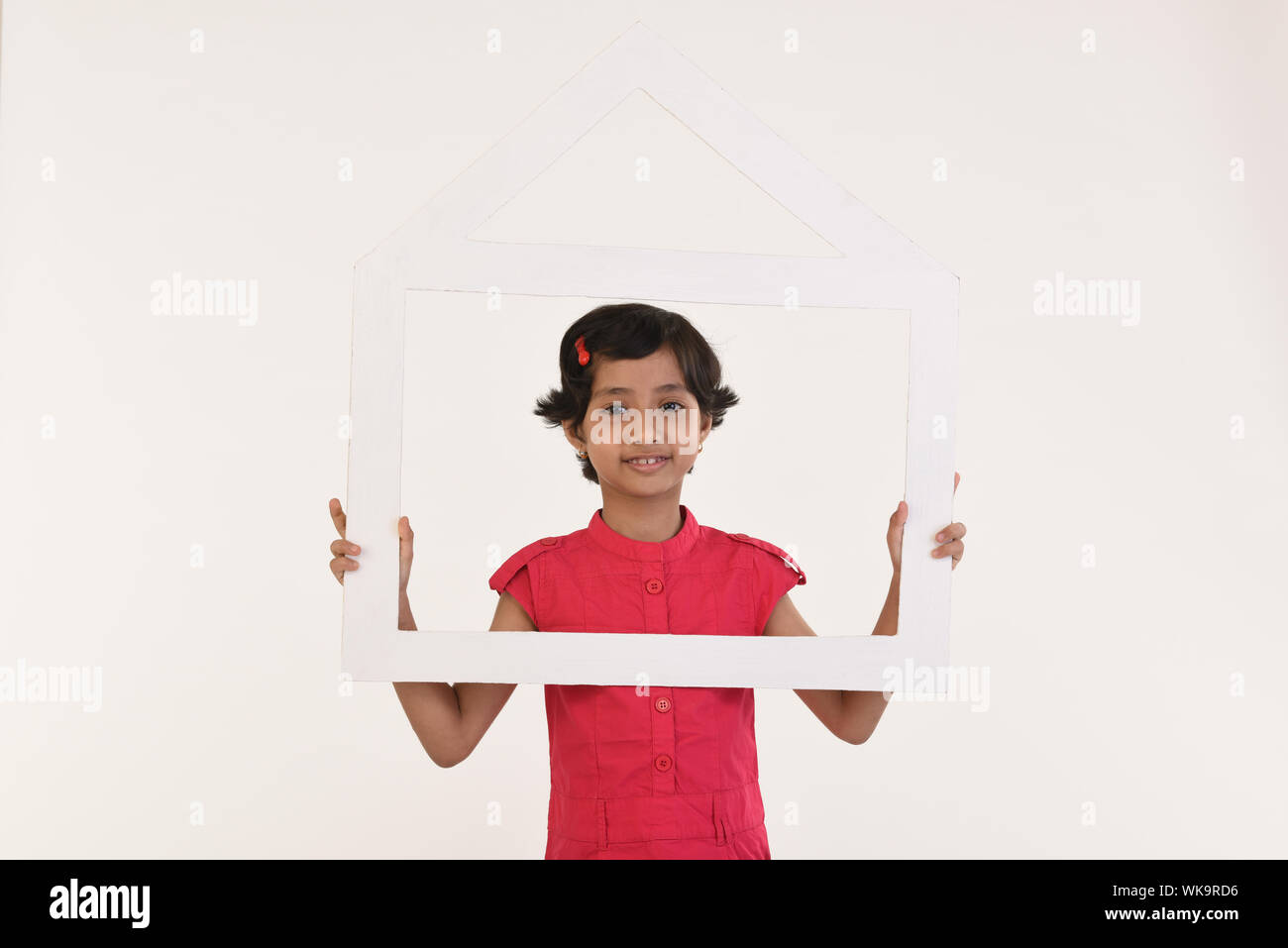 Girl holding a dream home shape frame Stock Photo - Alamy