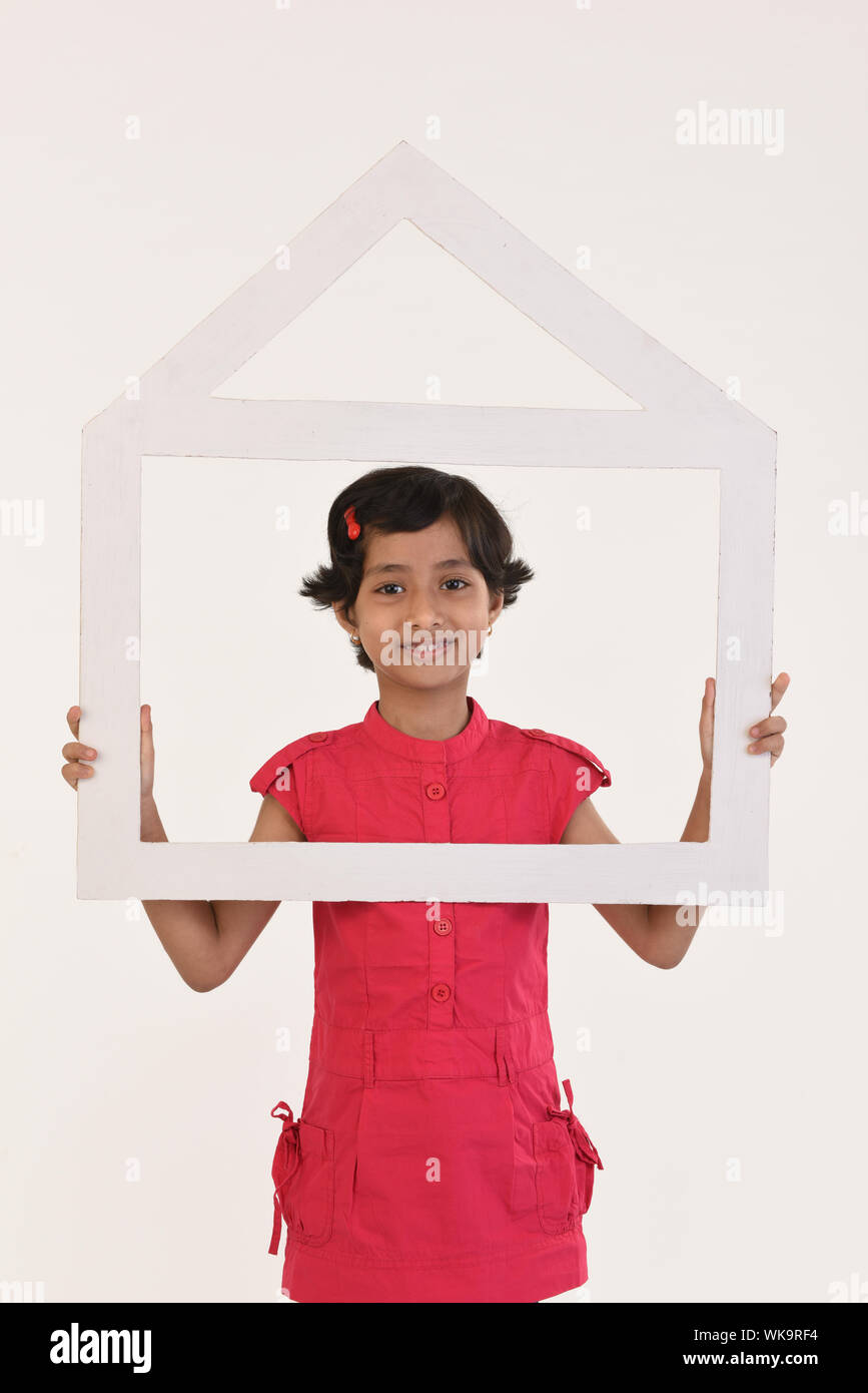 Girl holding a dream home shape frame Stock Photo - Alamy