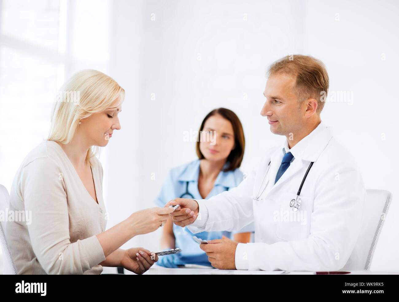 healthcare and medical concept - doctor giving tablets to patient in ...