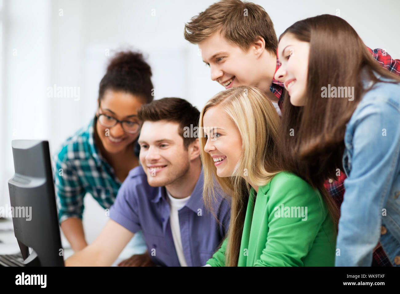 education concept - students looking at computer monitor at school ...