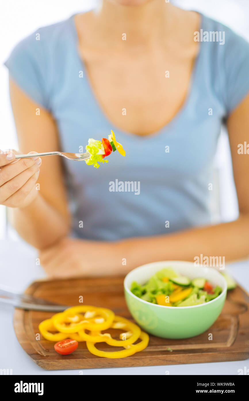 healthy food and kitchen concept - woman hand holding fork with ...