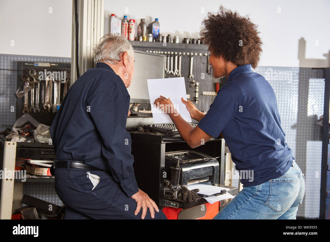 Automotive workshop team discusses inspection or repair order with ...