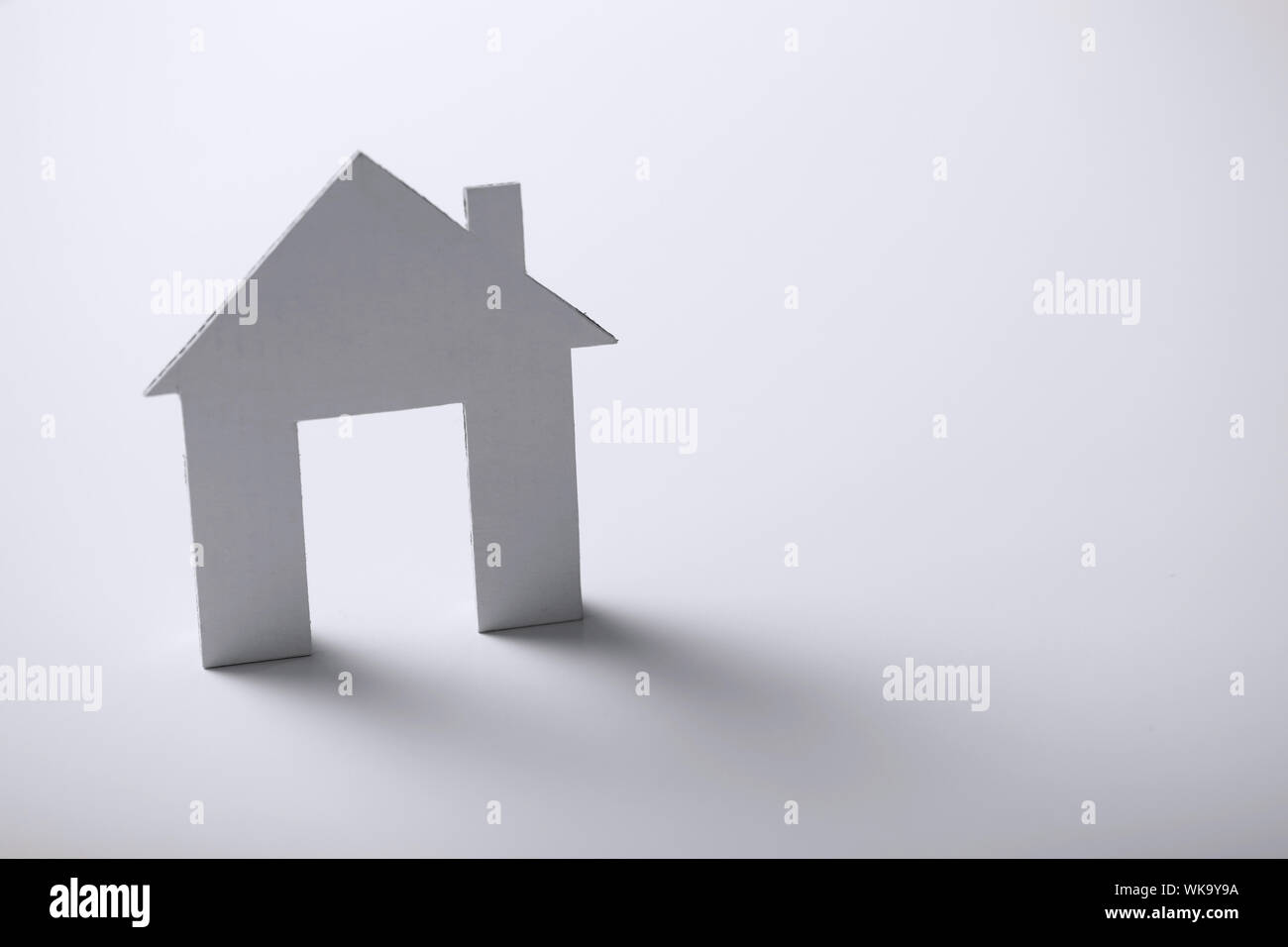 business and real estate concept - white paper house over white ...