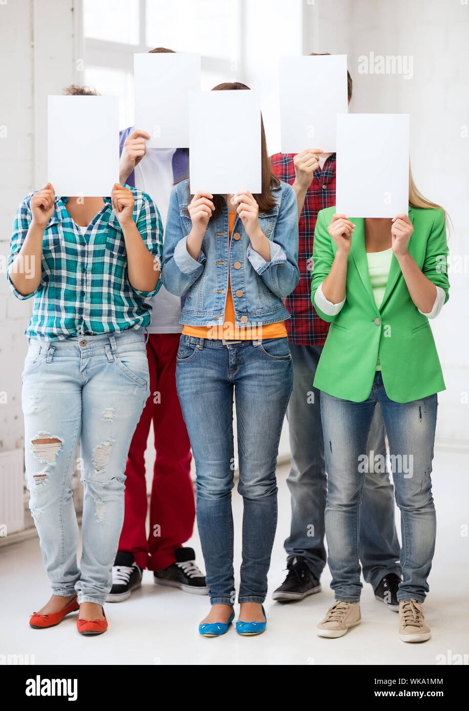 students covering faces with blank papers Stock Photo - Alamy