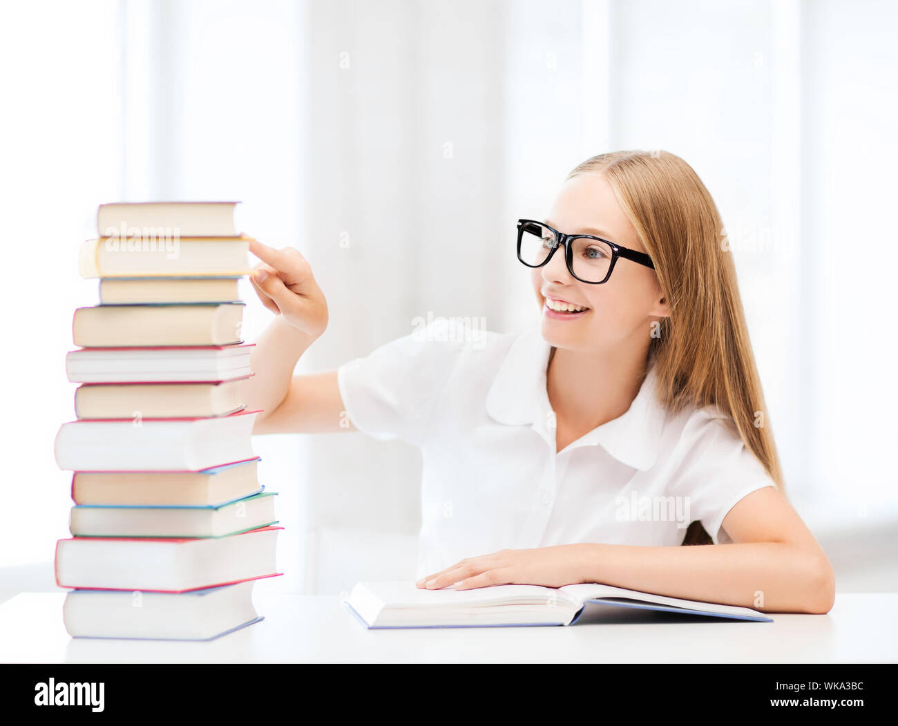 education and school concept - little student girl studying and reading ...