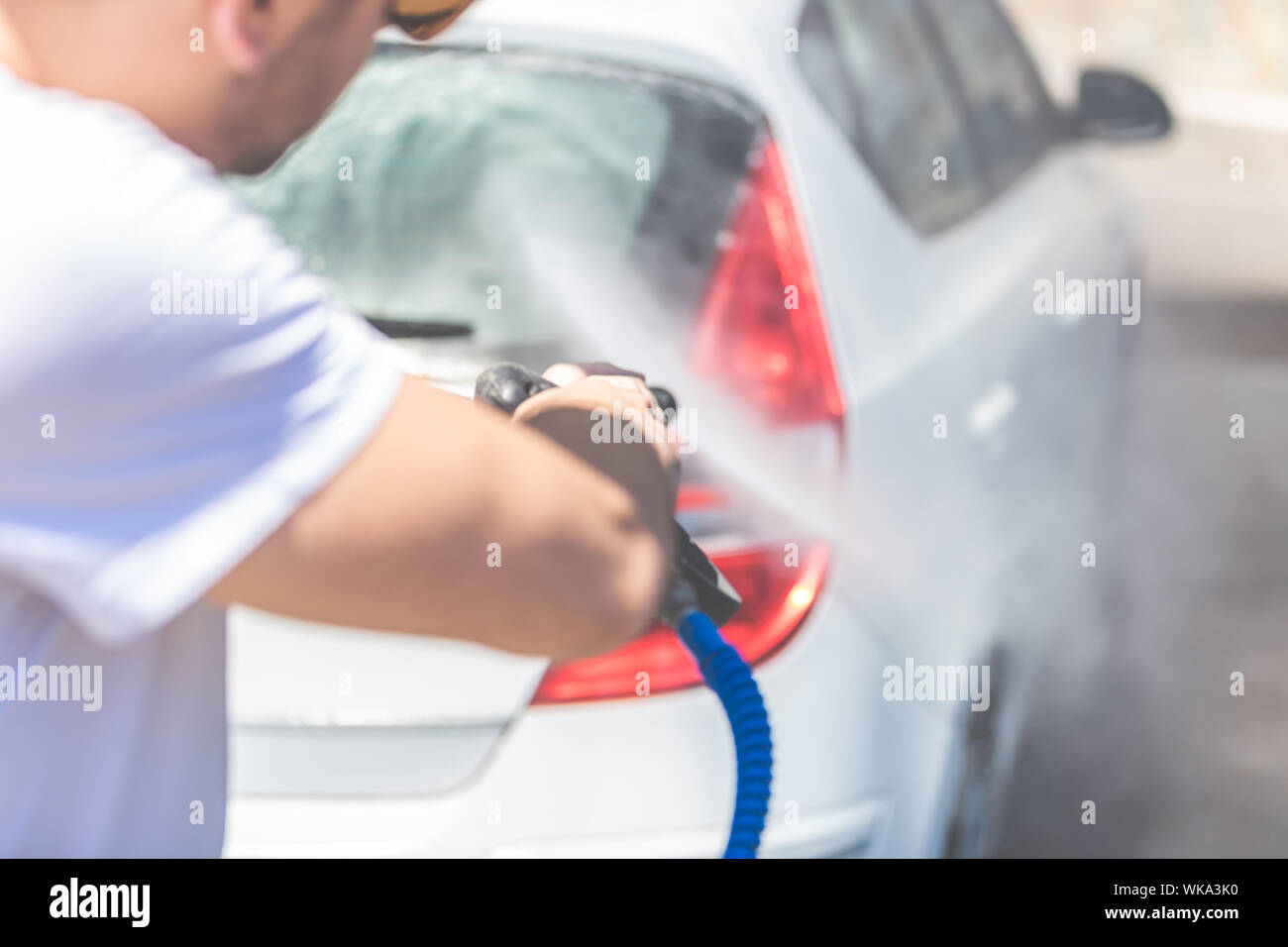 Rear lights and trunk washing with pressurized water in car wash ...