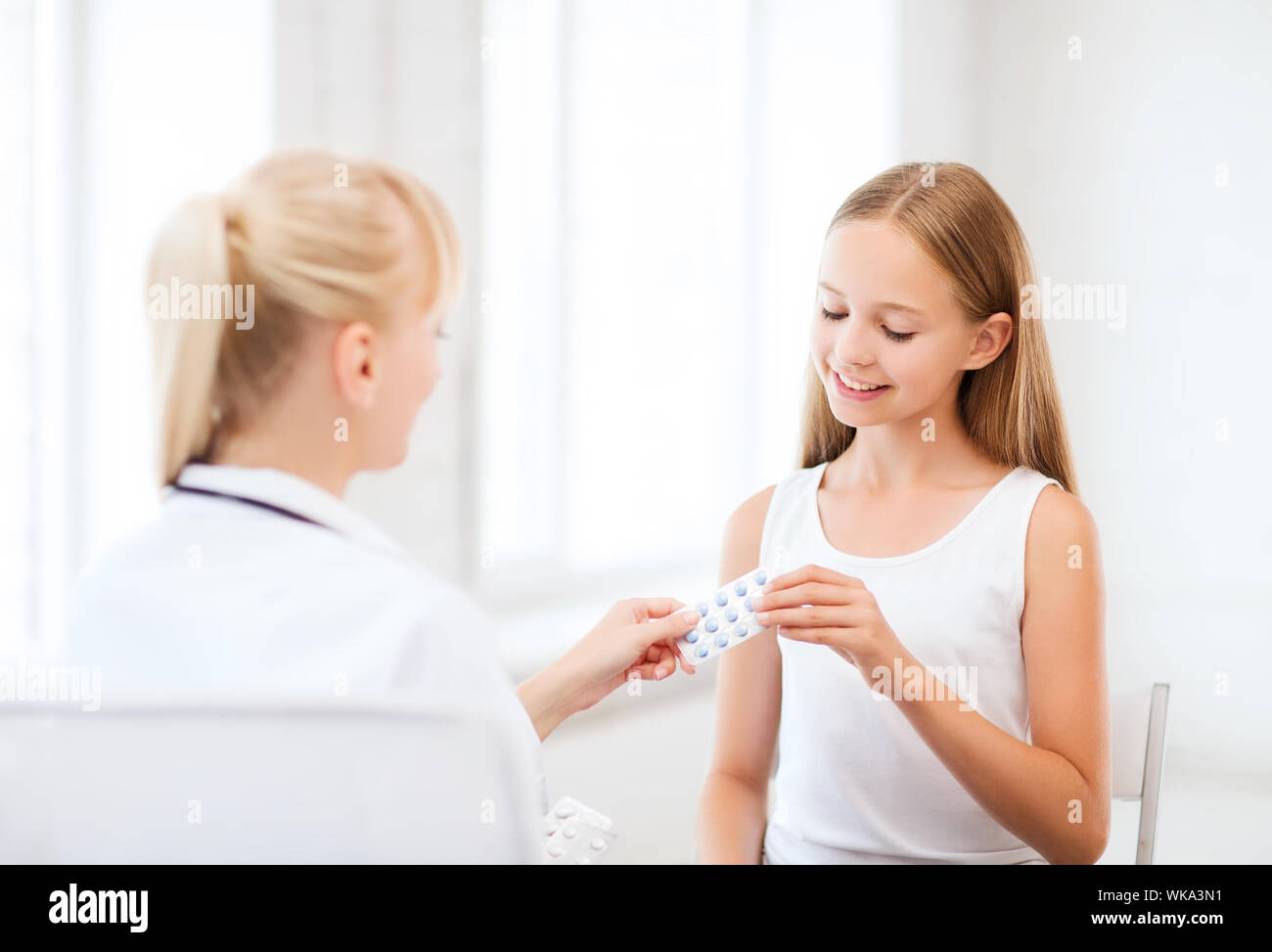 healthcare and medical concept - doctor giving tablets to child in ...