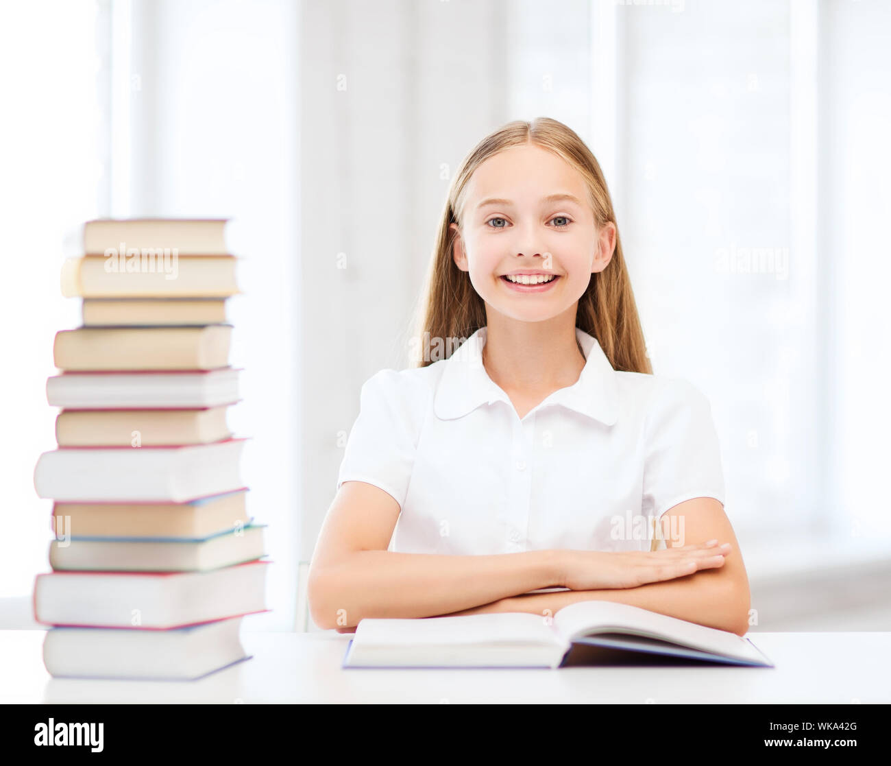education and school concept - little student girl studying and reading ...