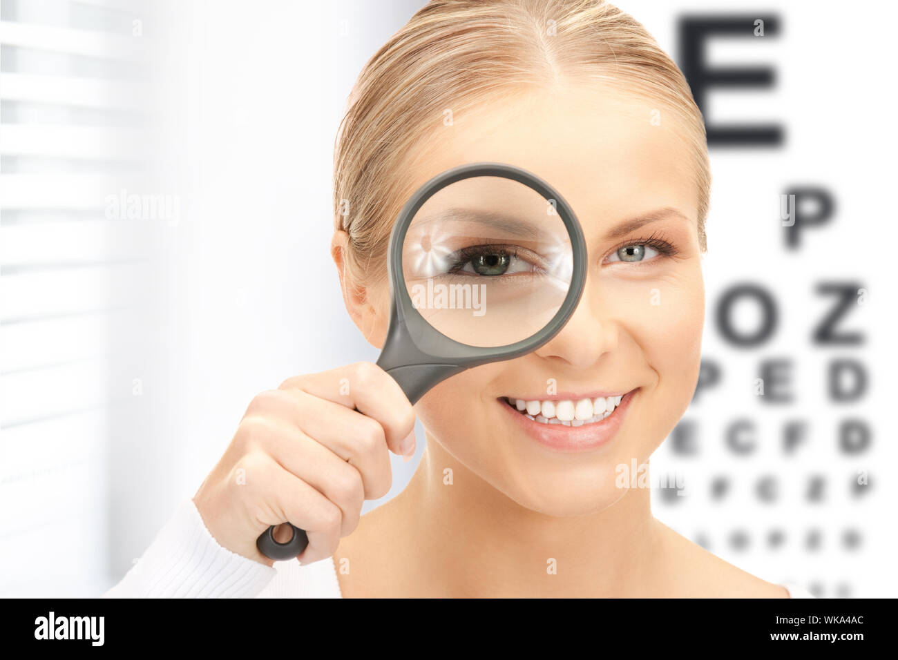 woman with magnifier and eye chart Stock Photo - Alamy