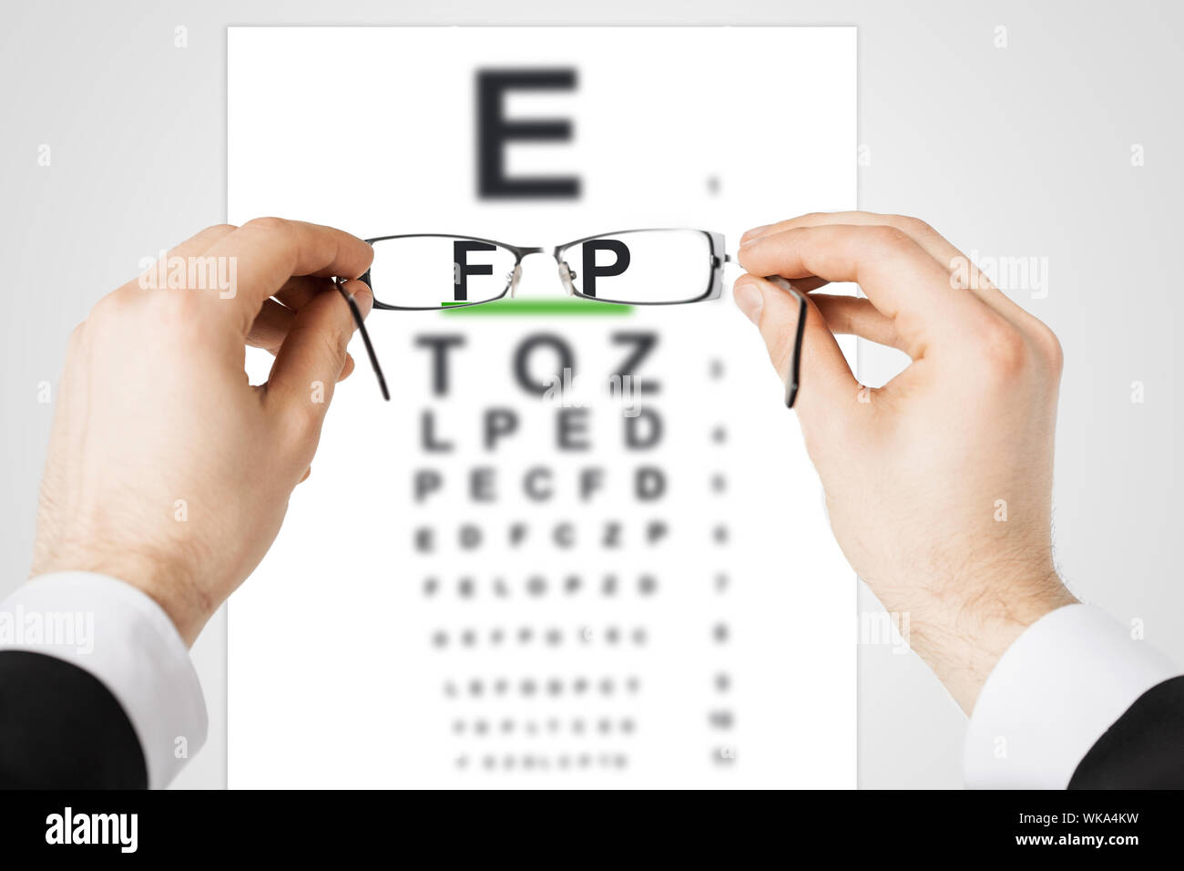 medicine and vision concept - man looking at eye chart through ...