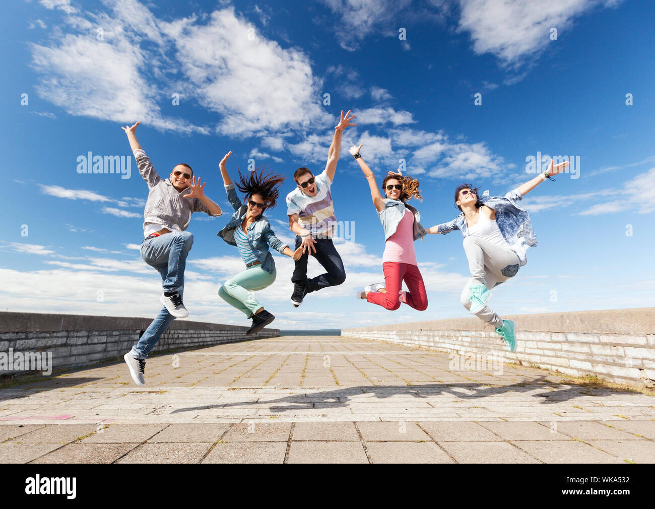group of teenagers jumping Stock Photo - Alamy