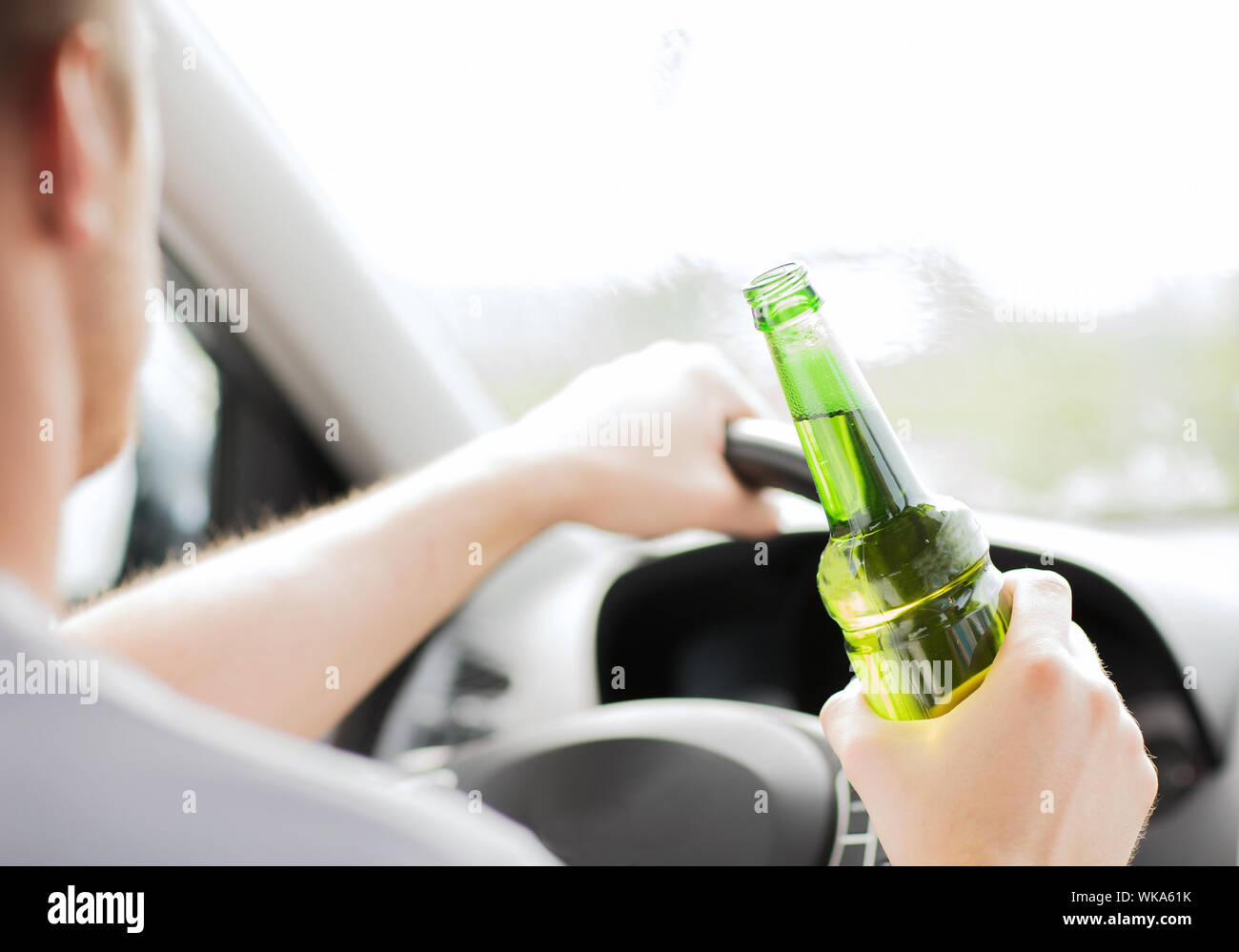 transportation and vehicle concept - man drinking alcohol while driving ...