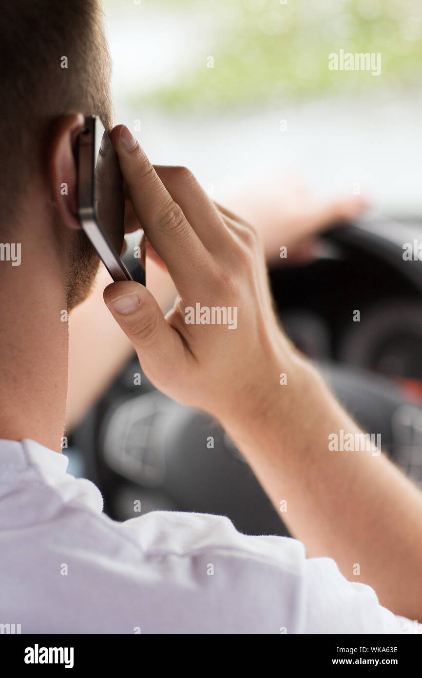 transportation and vehicle concept - man using phone while driving the ...