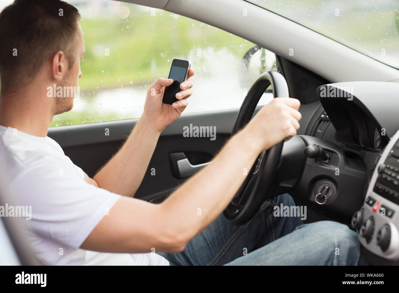 transportation and vehicle concept - man using phone while driving the ...