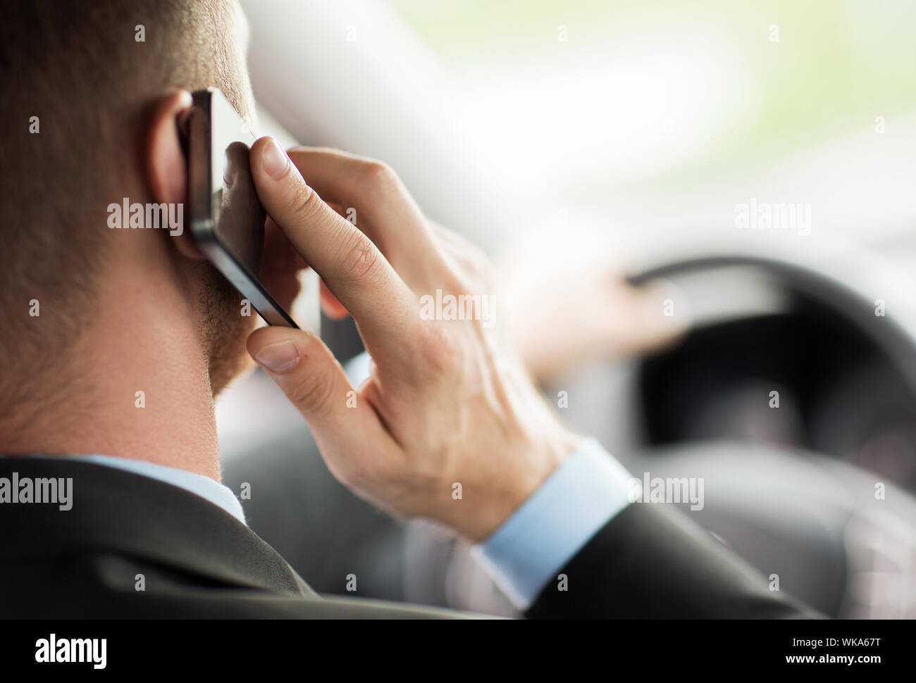 transportation and vehicle concept - man using phone while driving the ...