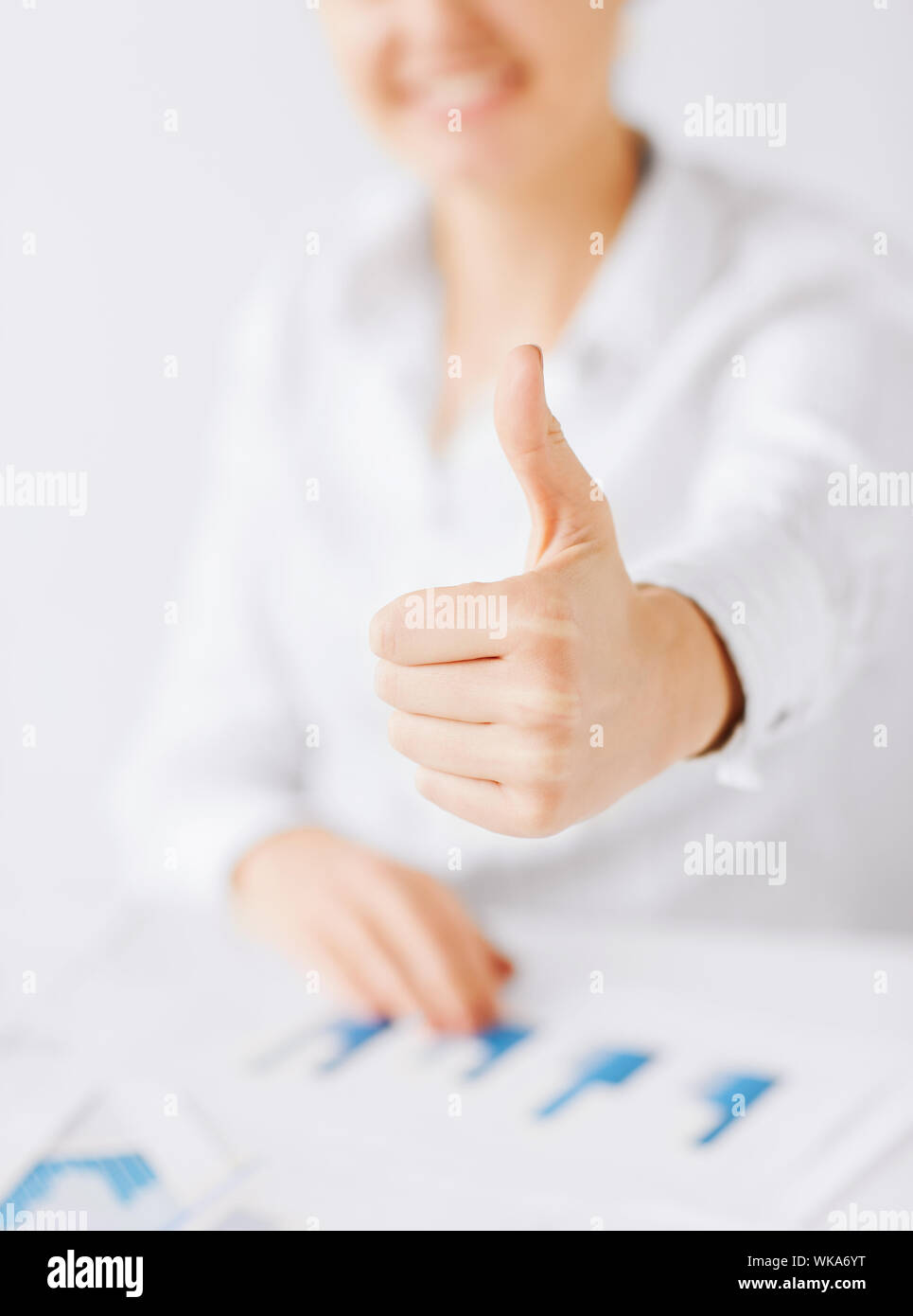 woman with charts, papers and thumbs up Stock Photo - Alamy