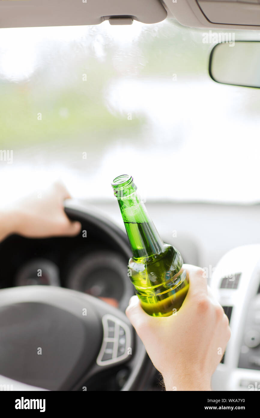 transportation and vehicle concept - man drinking alcohol while driving ...