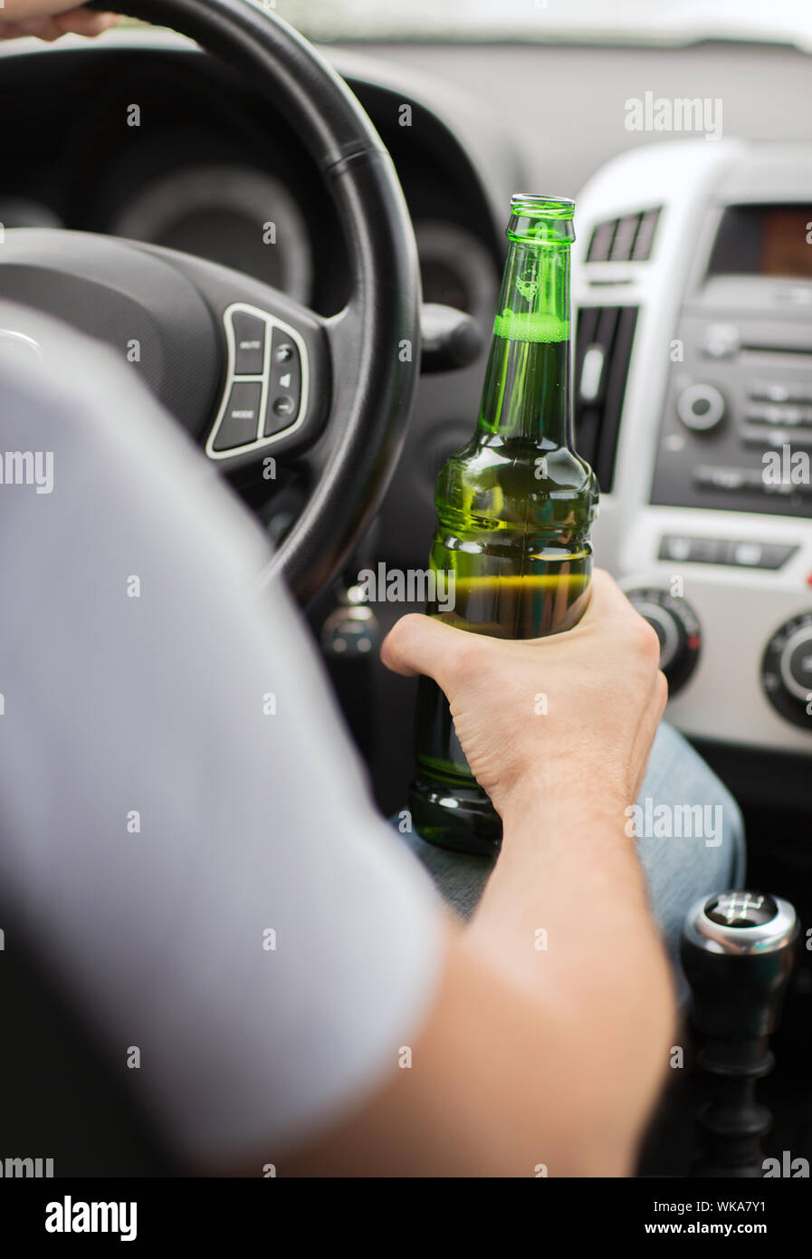 transportation and vehicle concept - man drinking alcohol while driving ...