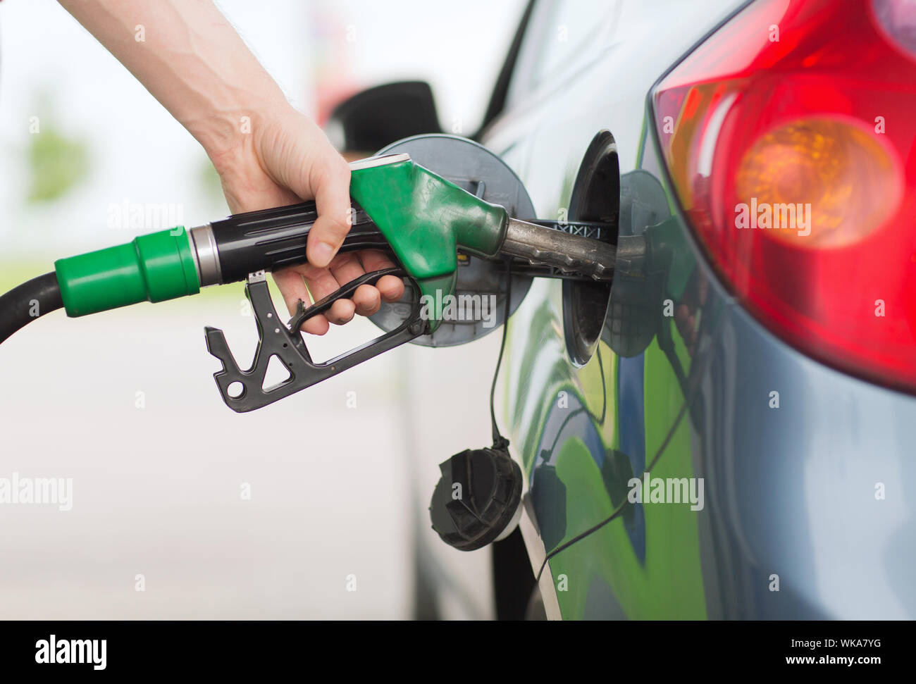 transportation and ownership concept - man pumping gasoline fuel in car ...
