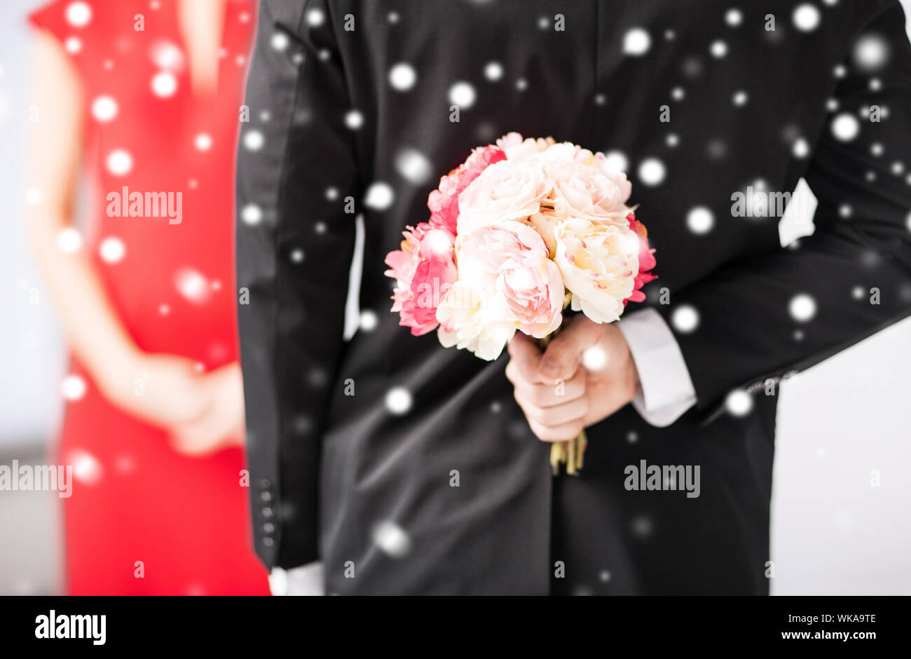 love, romance, holiday, celebration concept - man hiding bouquet of ...