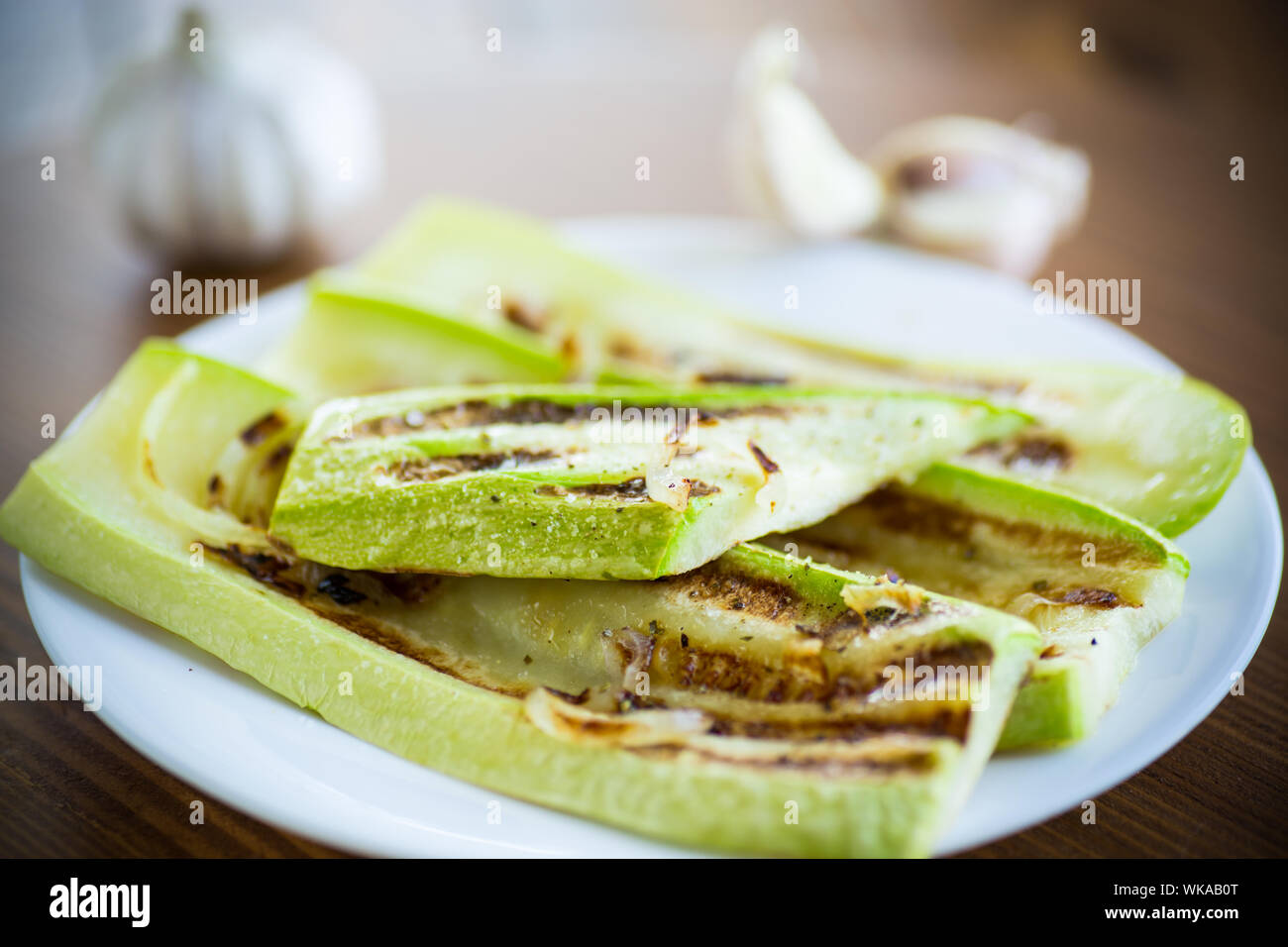 grilled zucchini with onions in a plate, on a table Stock Photo - Alamy