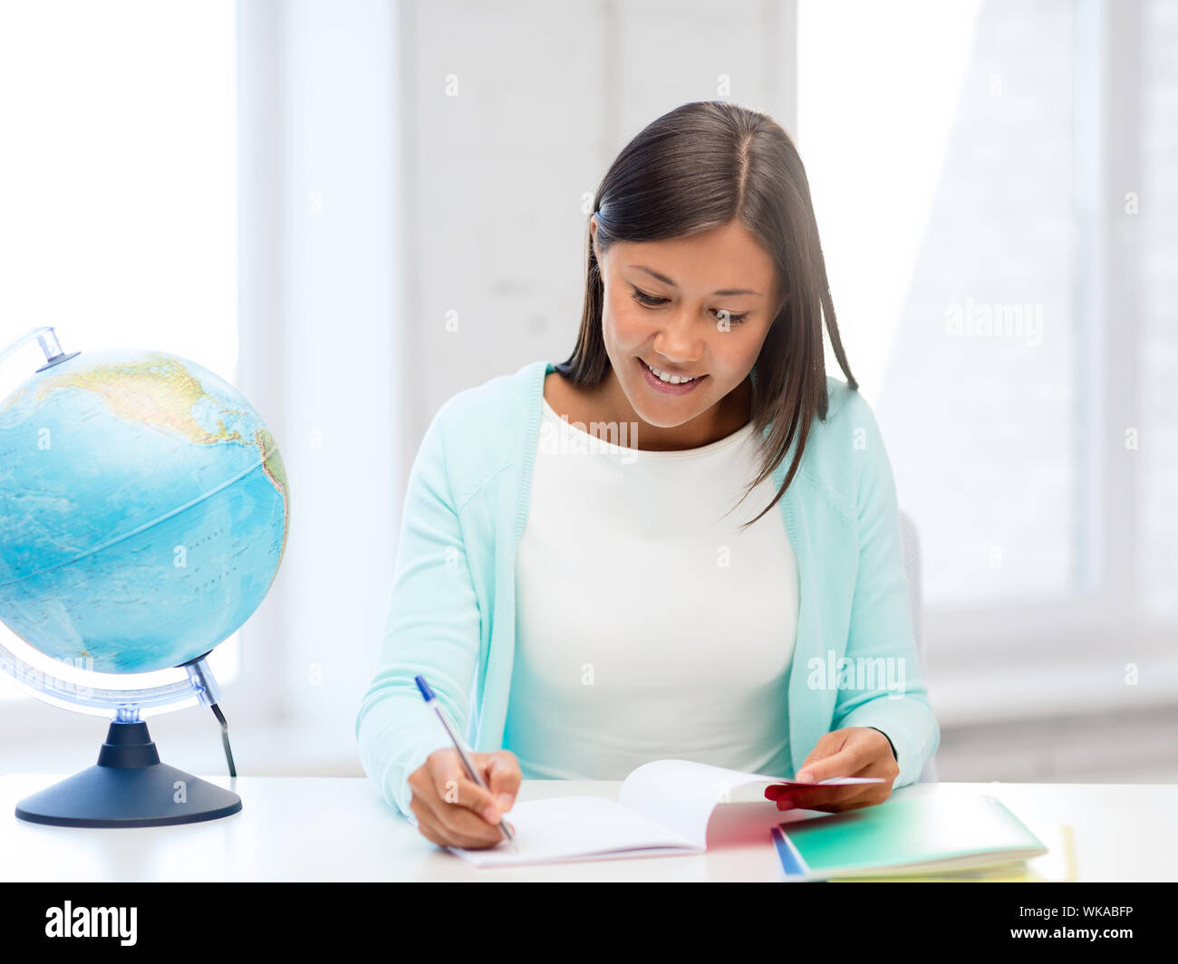 teacher with globe and notepad at school Stock Photo - Alamy
