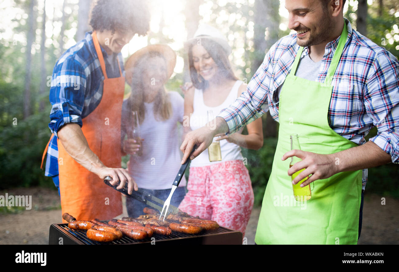 Happy friends enjoying barbecue and grill party outdoor Stock Photo - Alamy