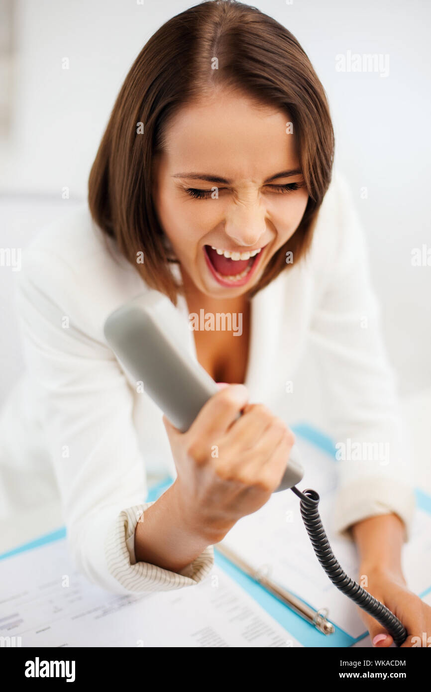 business, anger, bad boss concept - woman shouting into phone in office ...
