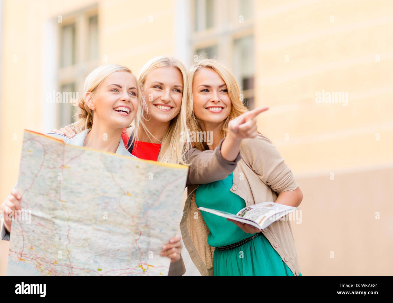 holidays and tourism concept - beautiful blonde women with tourist map ...