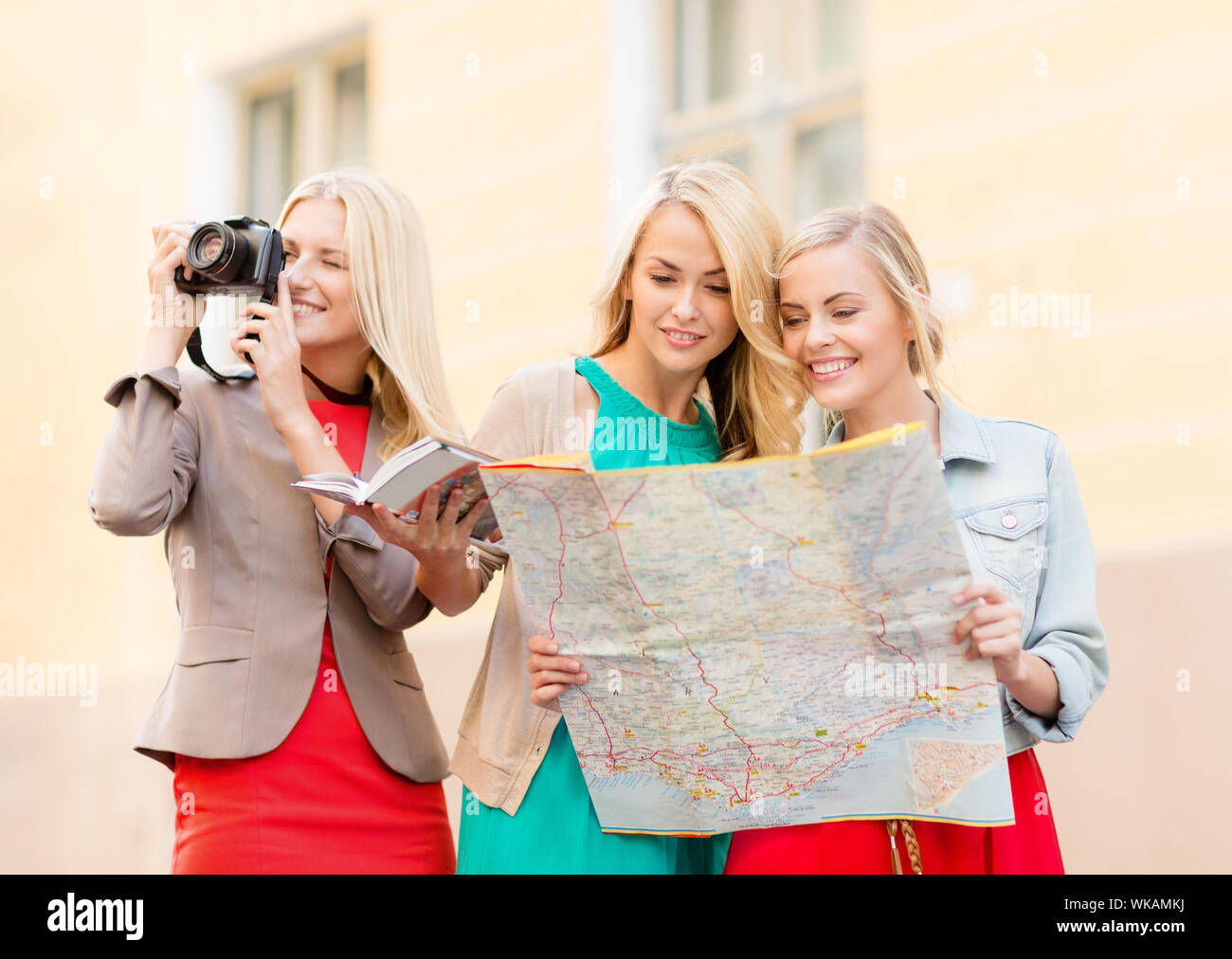 holidays and tourism concept - beautiful blonde women with tourist map ...