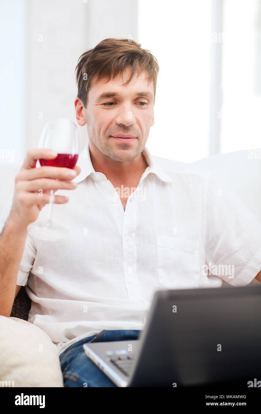 man with laptop computer and glass of rose wine Stock Photo - Alamy
