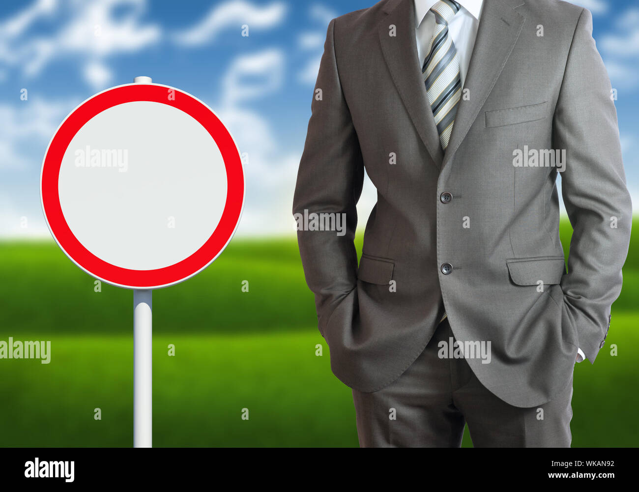 Businessman with road sign. Blue sky and green grass as backdrop Stock ...