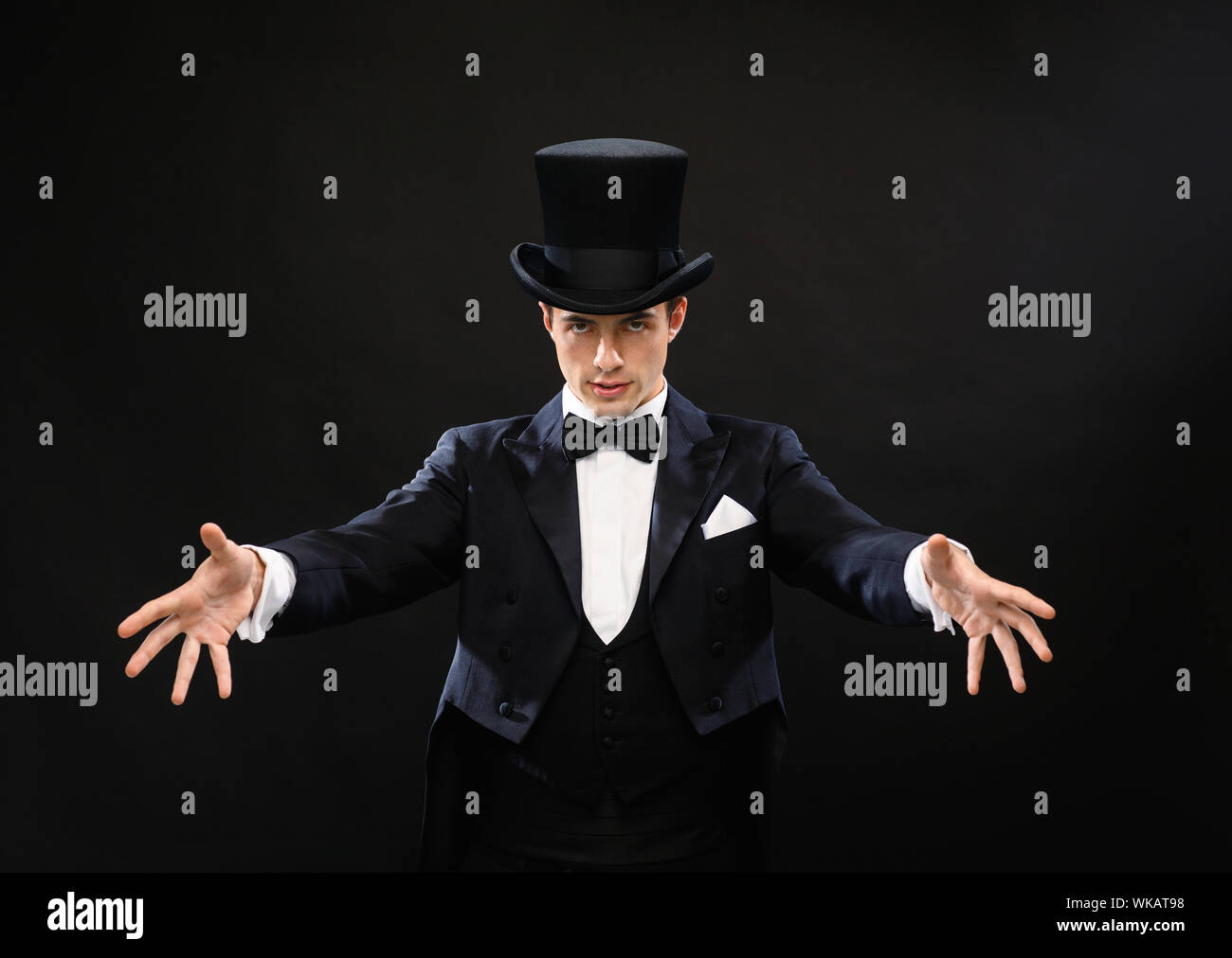 magic, performance, circus, show concept - magician in top hat showing ...