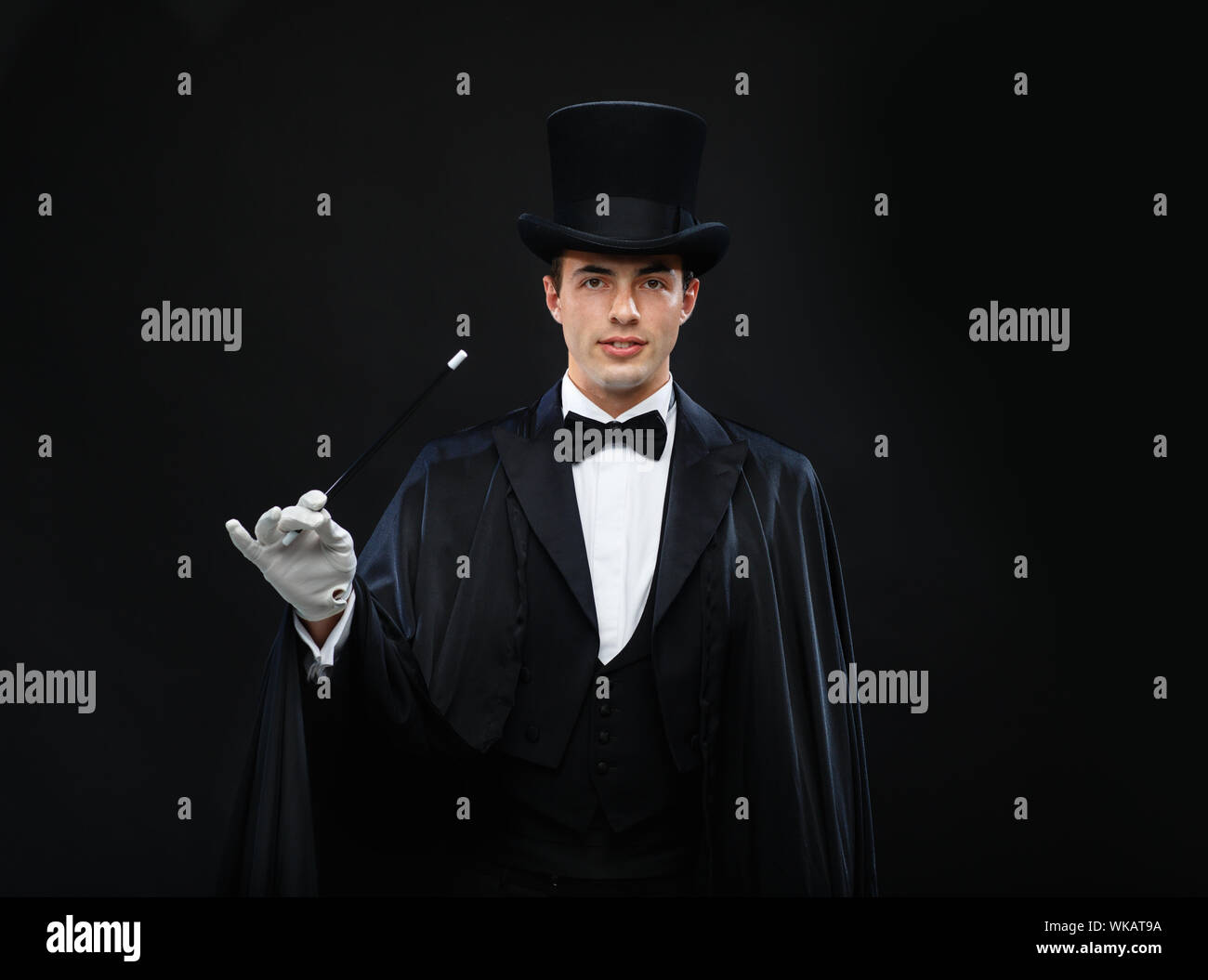 performance, circus, show concept - magician in top hat with magic wand ...