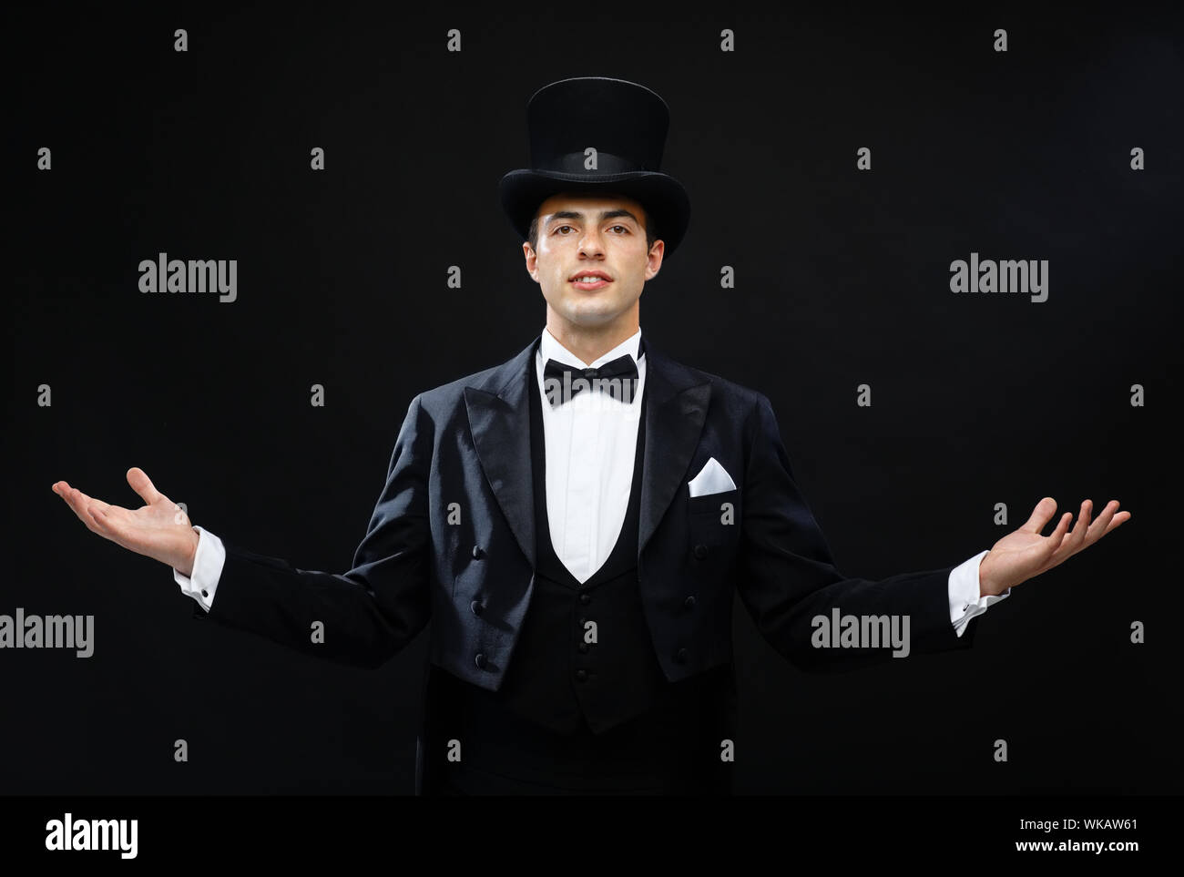 magic, performance, circus, show concept - magician in top hat showing ...
