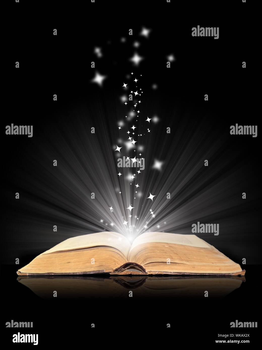 Open book magic on black Stock Photo - Alamy