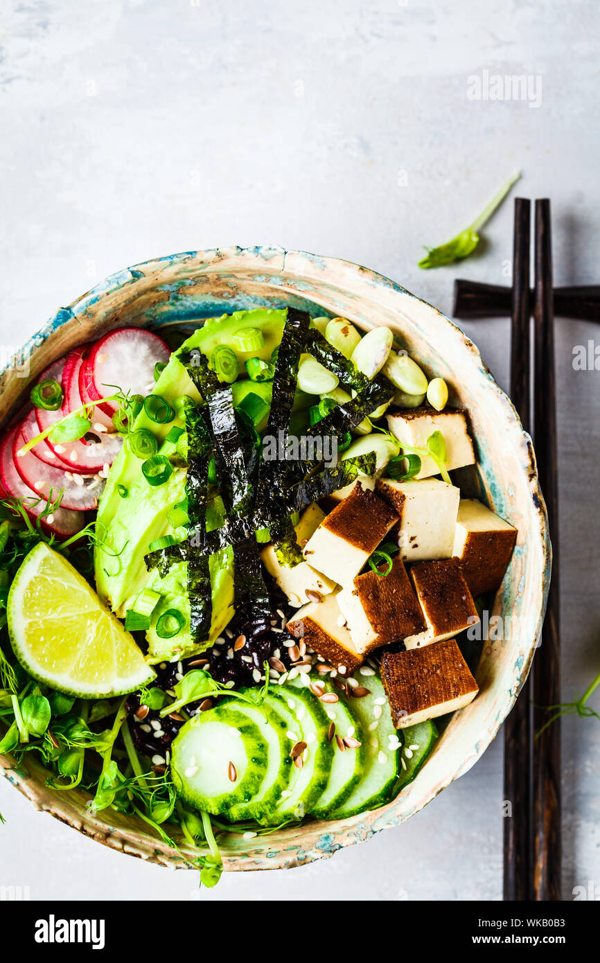 Poke bowl with avocado, black rice, smoked tofu, vegetables, sprouts ...