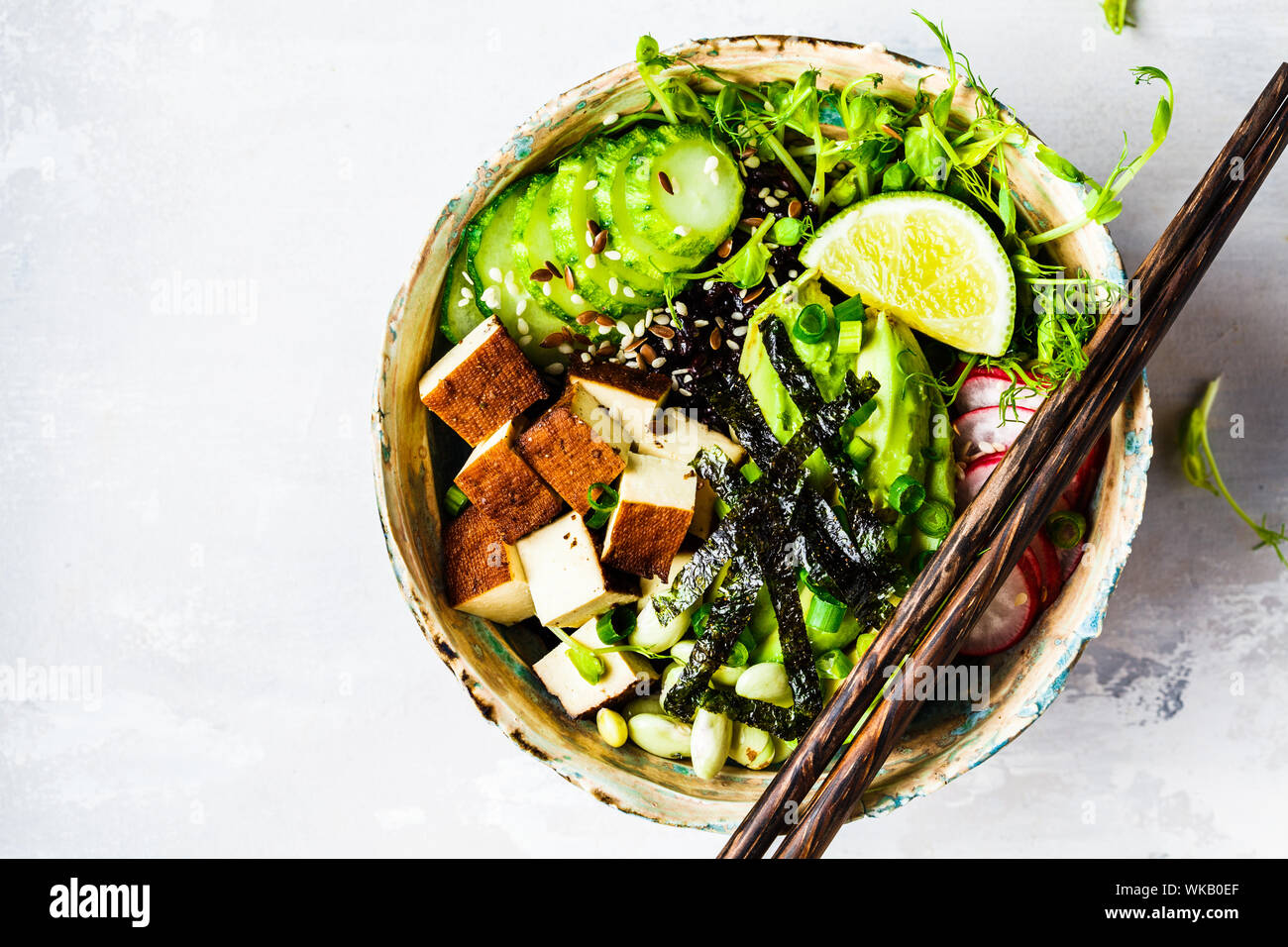 Poke bowl with avocado, black rice, smoked tofu, vegetables, sprouts ...
